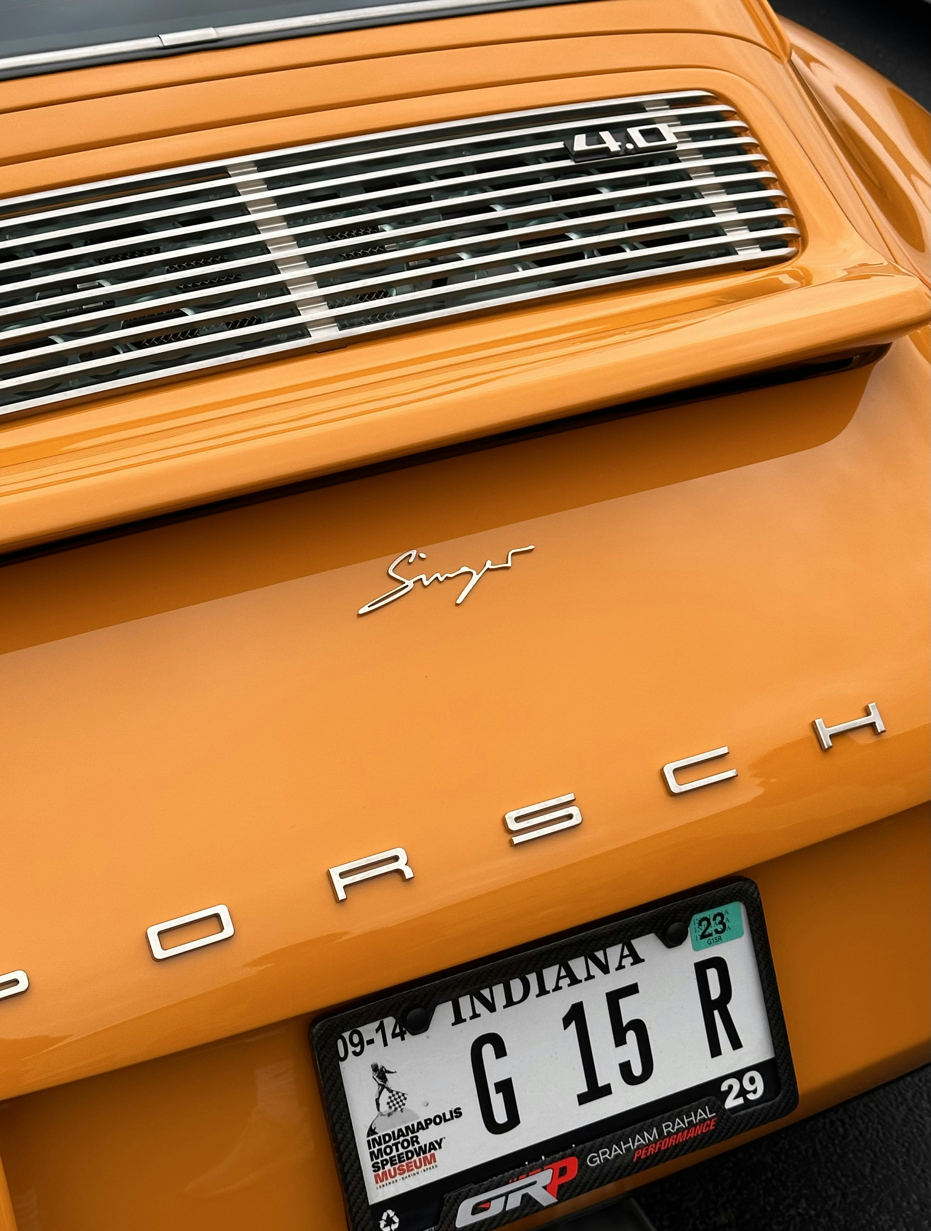 Sunlit Orange Porsche Rear Close-Up: Chrome Script, 4.0 Badge, and Indiana Plate