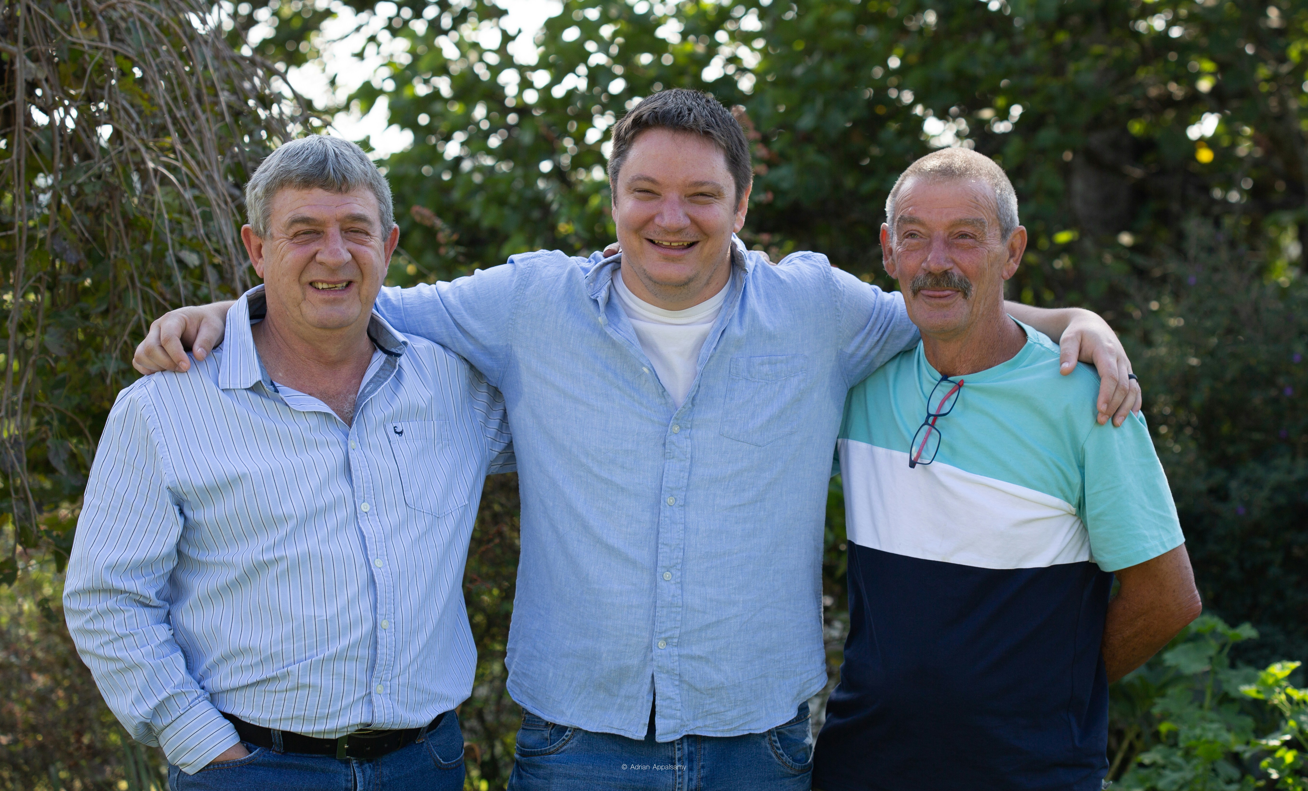 A group of three men standing next to each other photo – Free Portrait ...