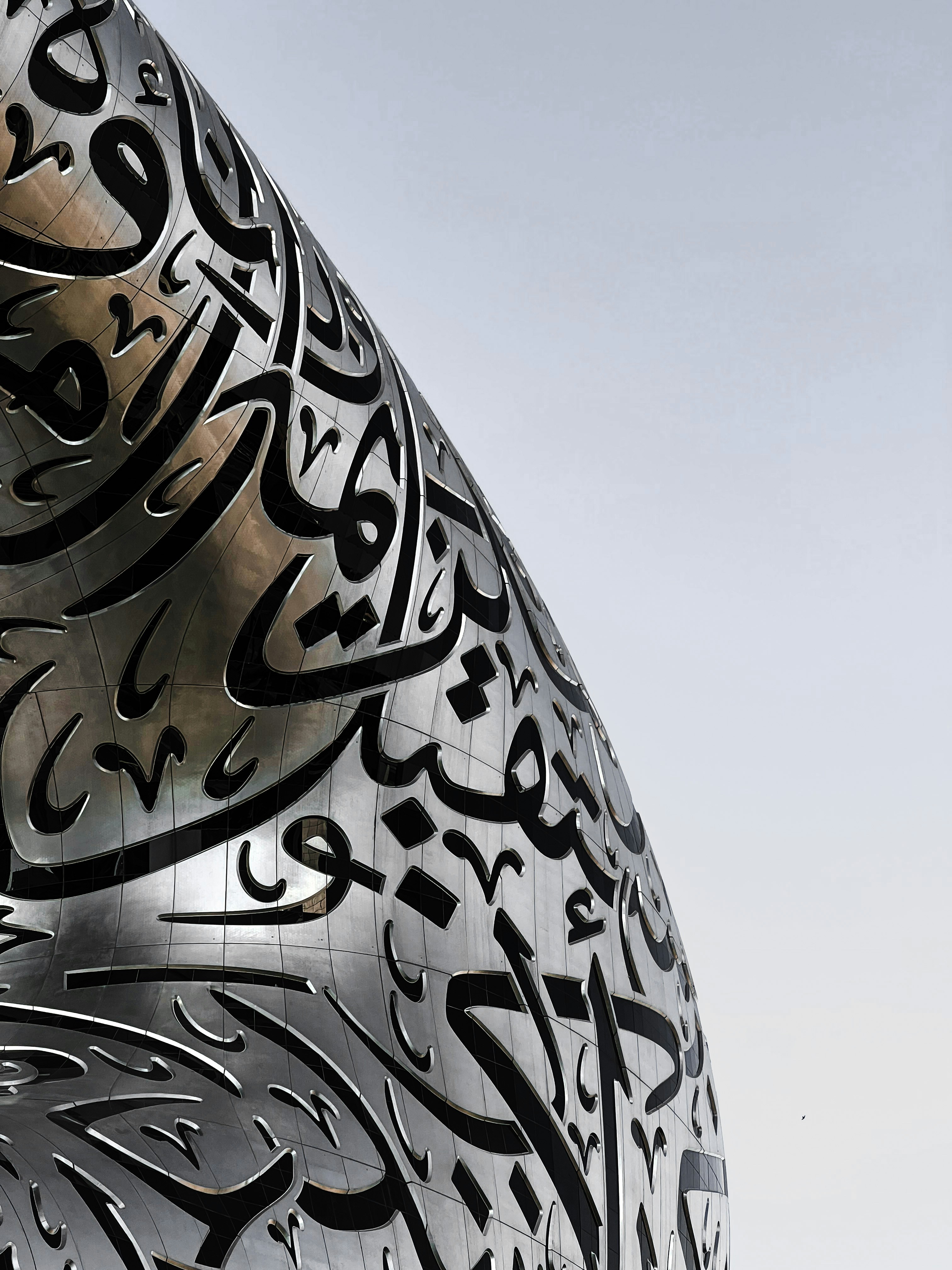 Curving Script: A Faceted Metal Facade Wrapped in Calligraphic Abstraction
