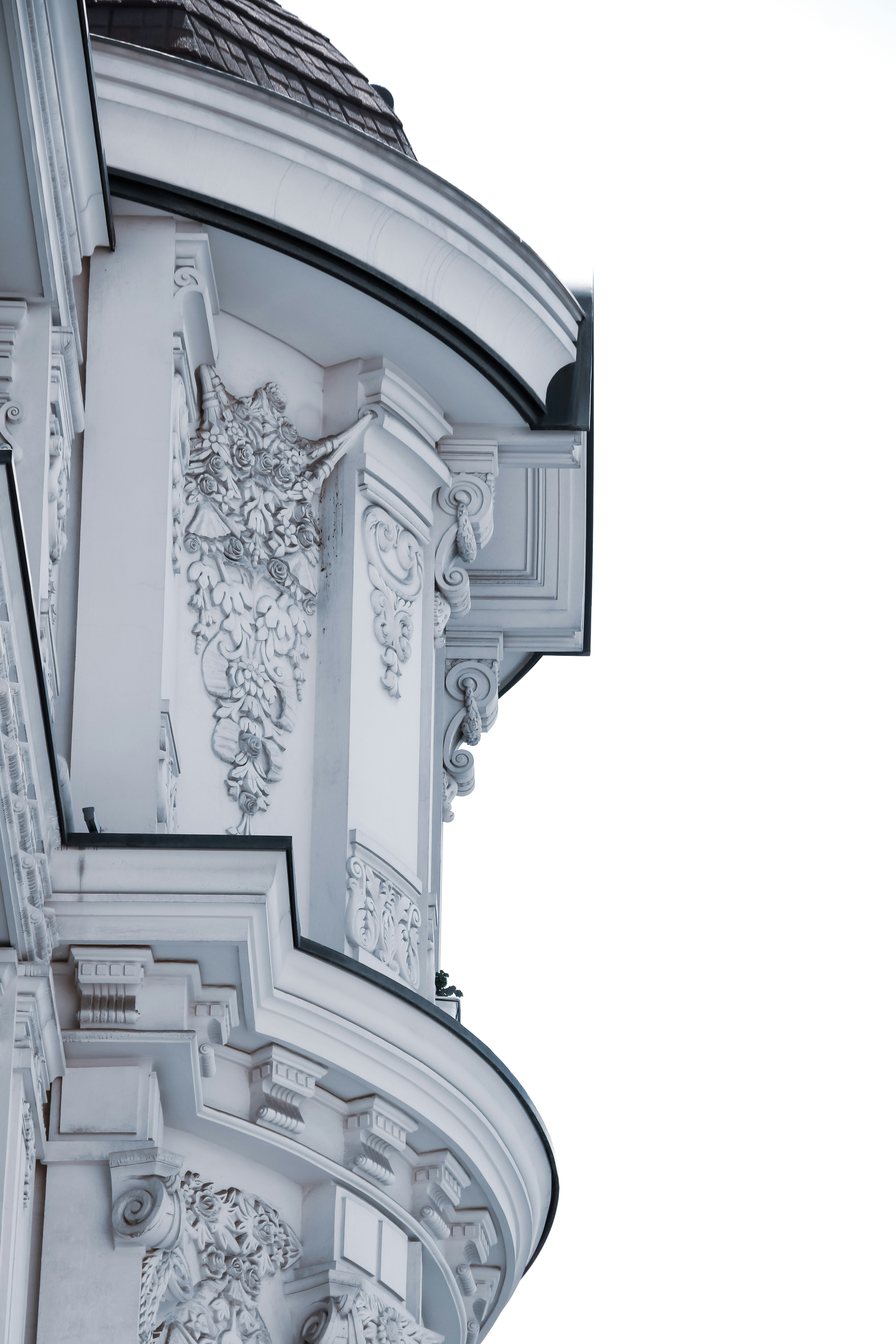 Ornate Cornerstone: Carved plaster on a pale facade under bright daylight
