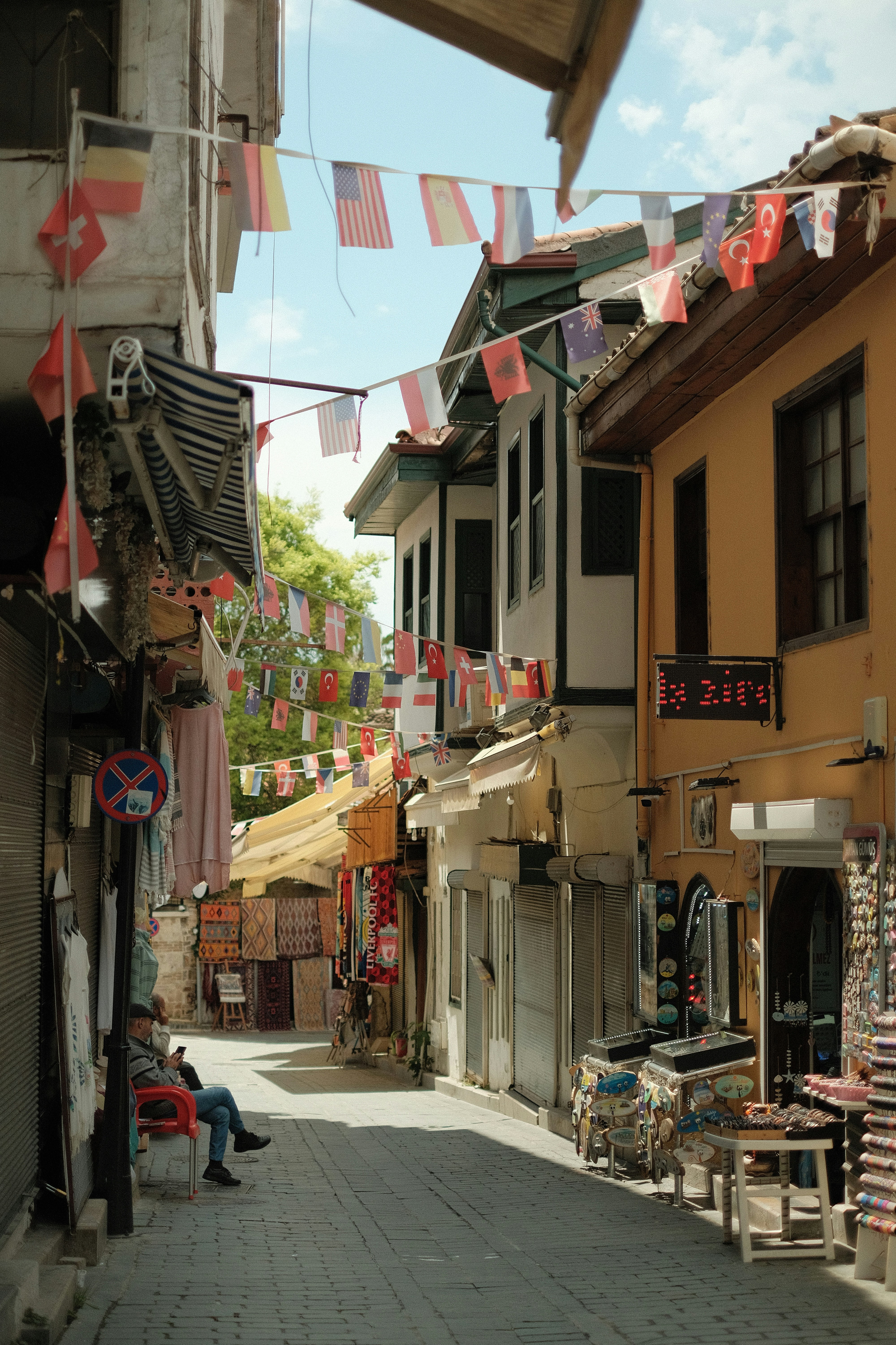 Flag-Woven Alley: A Sunlit Bazaar Corridor