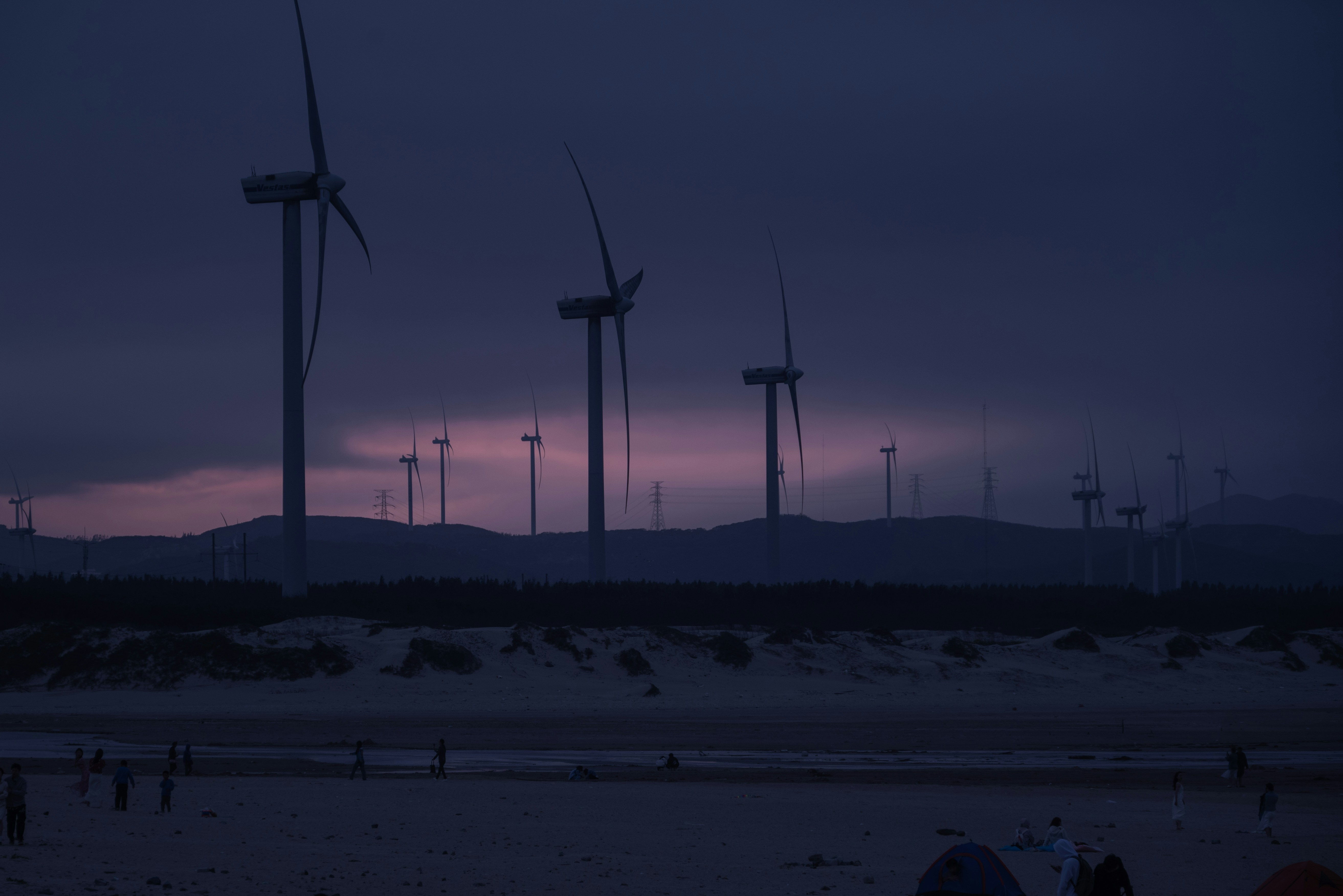 Twilight Turbines: Silent Giants on a Snow-Dusted Shore