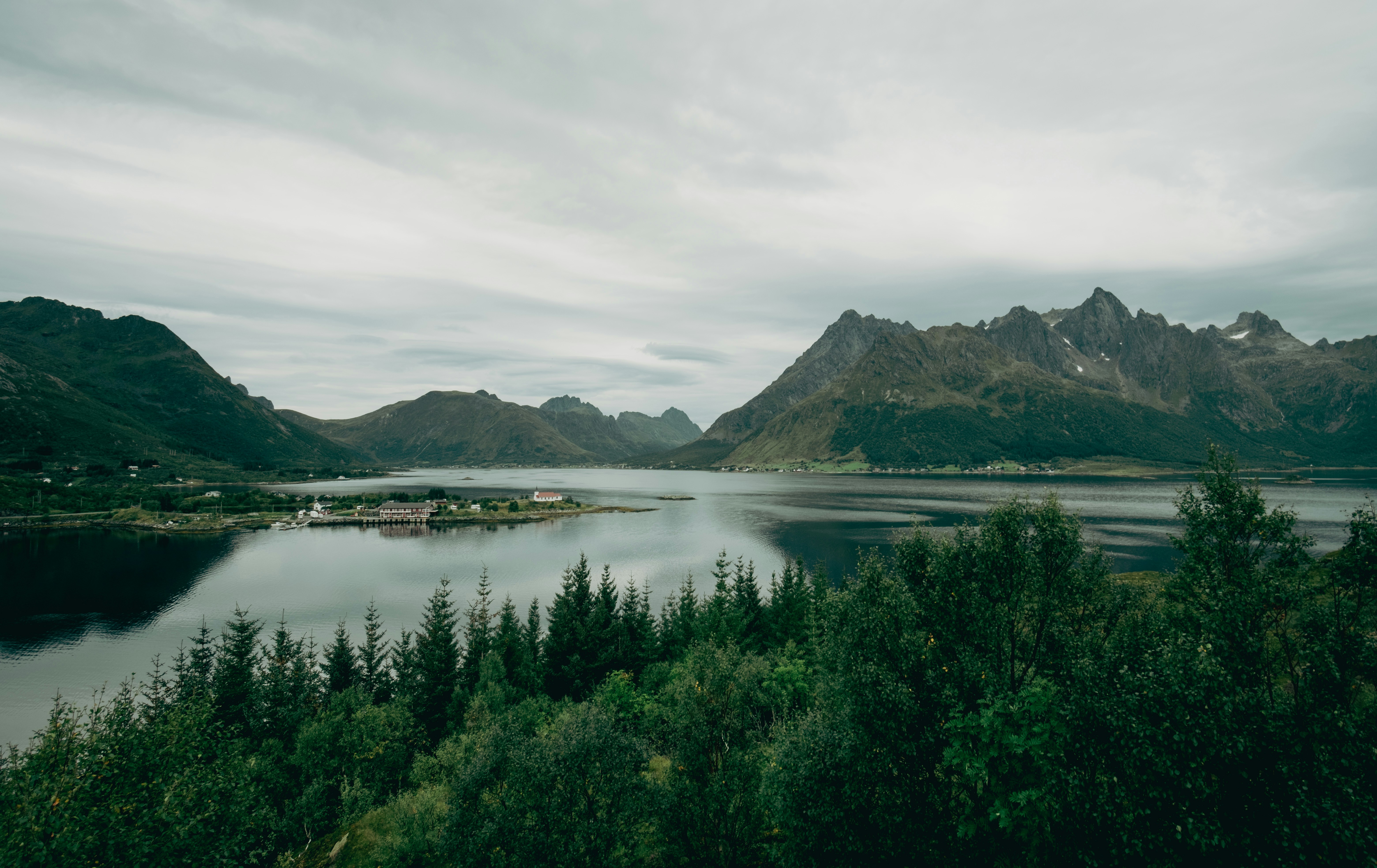 Tranquil island with a church surrounded by misty mountains and calm waters.