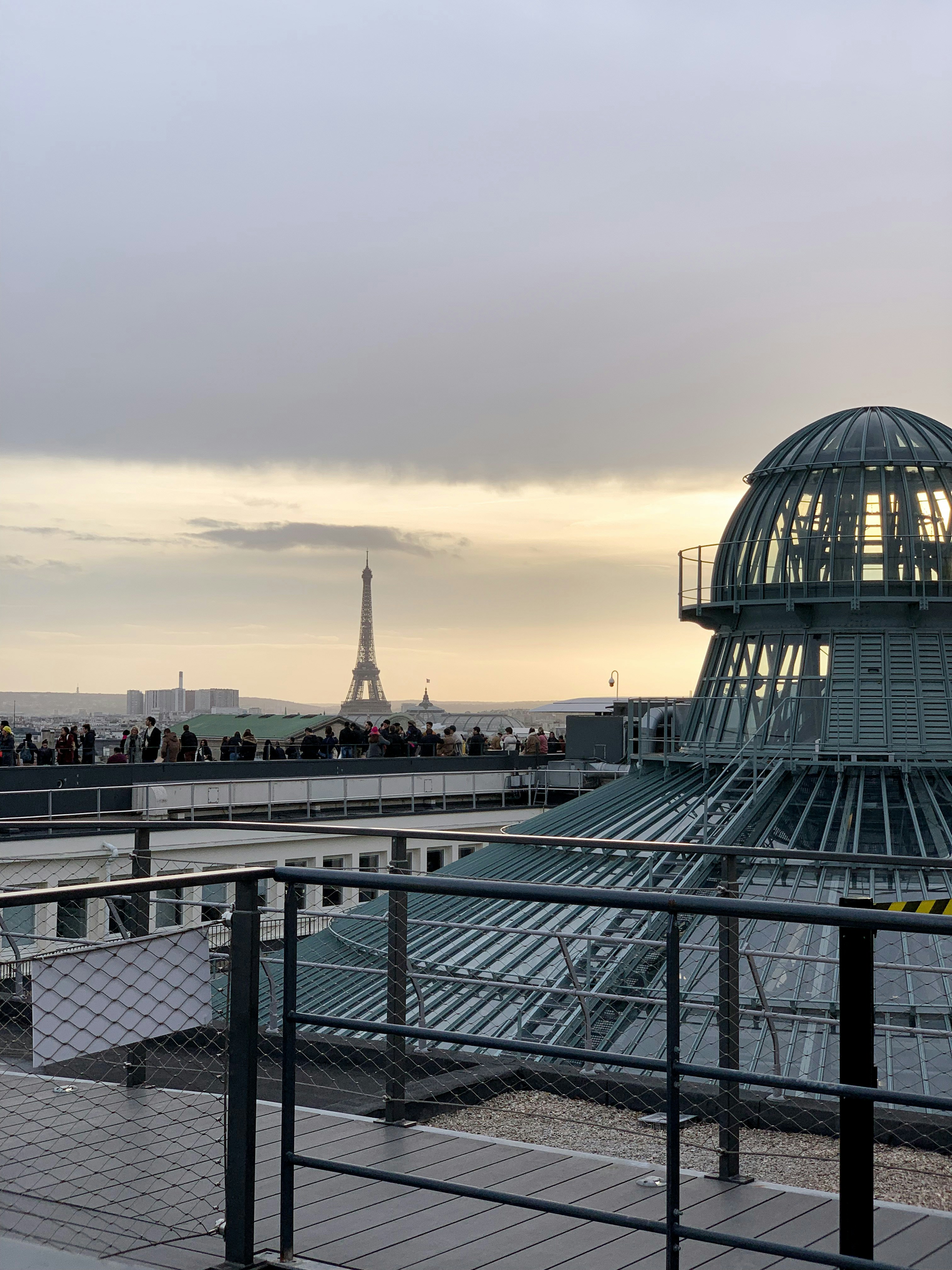 Rooftop Perspective: Eiffel Tower on the Horizon Framed by a Glass Dome at Sunset