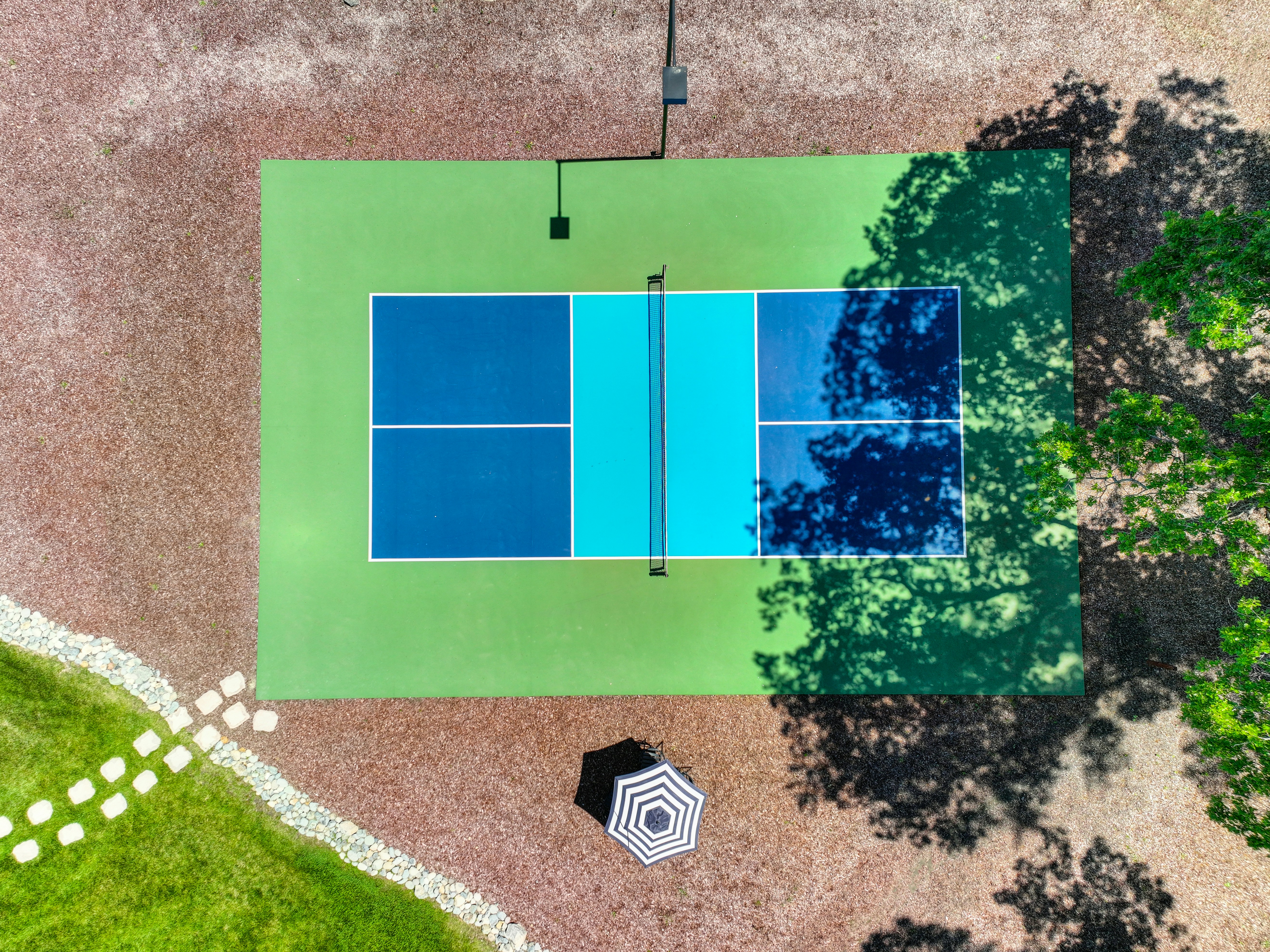 An aerial view of a tennis court with an umbrella photo – Free Paper ...