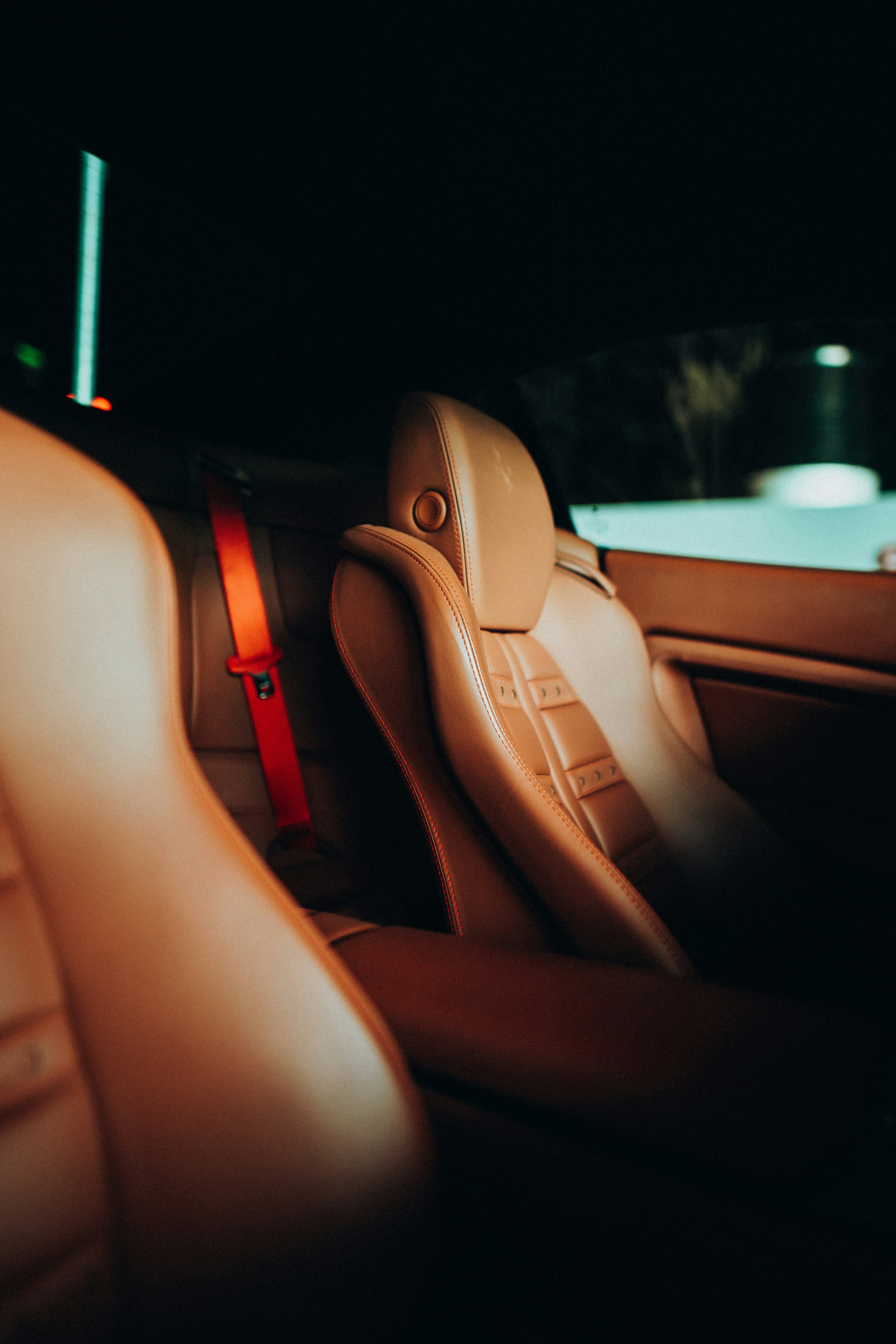 Neon Night in Tan Leather: A Quiet Car Cabin Illuminated by Street Glow