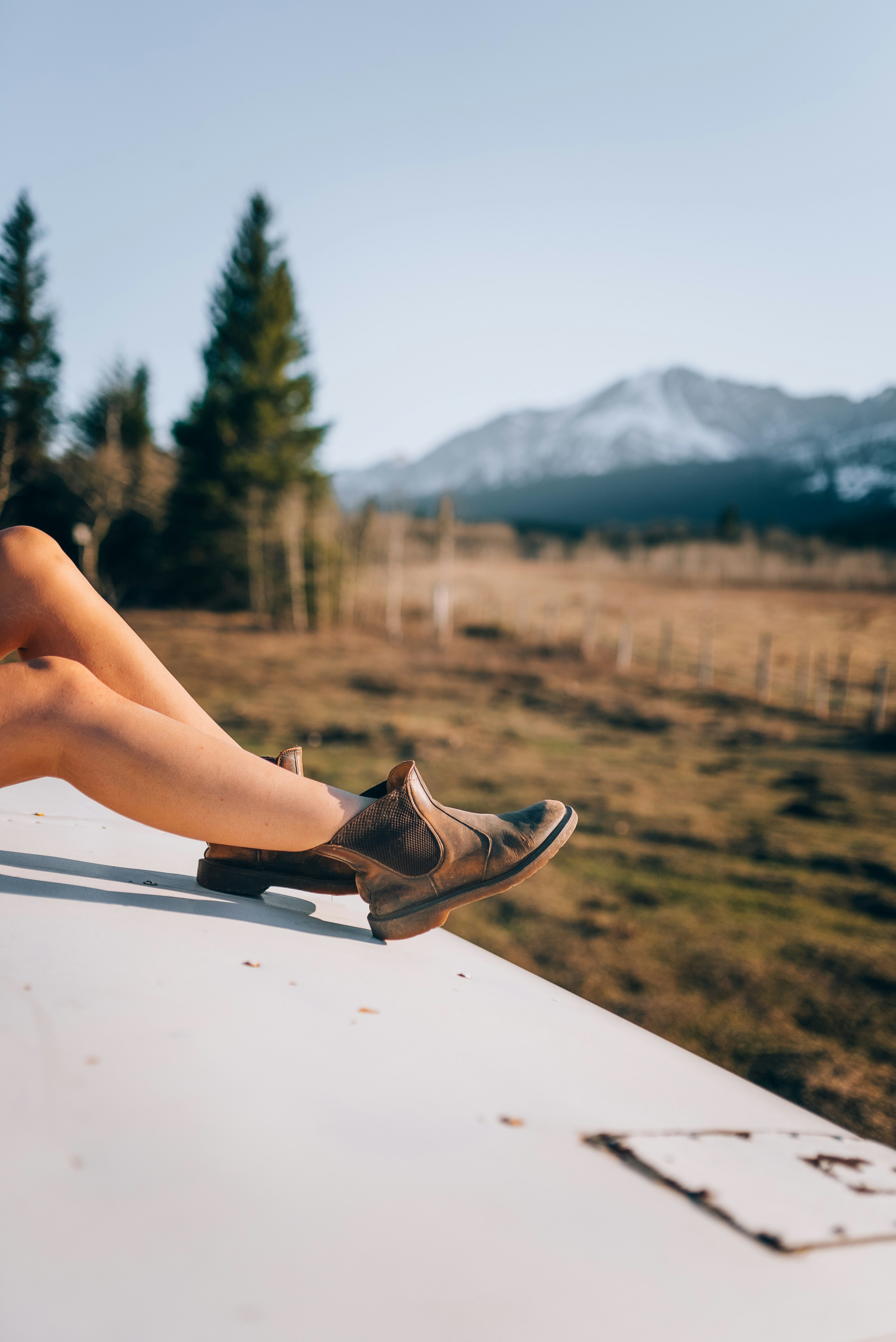 Boots on a Weathered Roof: A Quiet Sunset at the Field Edge