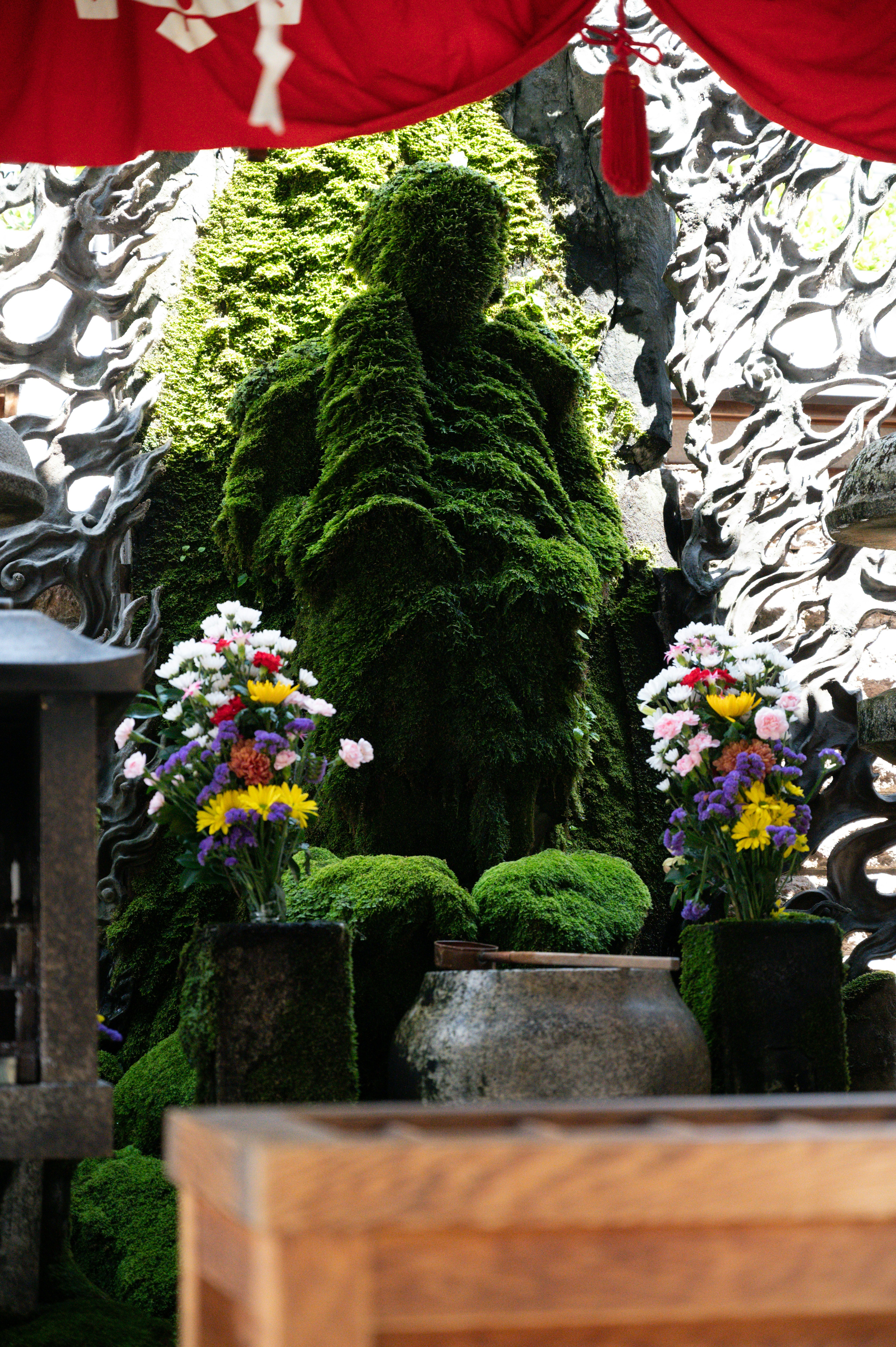 Moss-Covered Guardian Standing Amid a Floral Altar