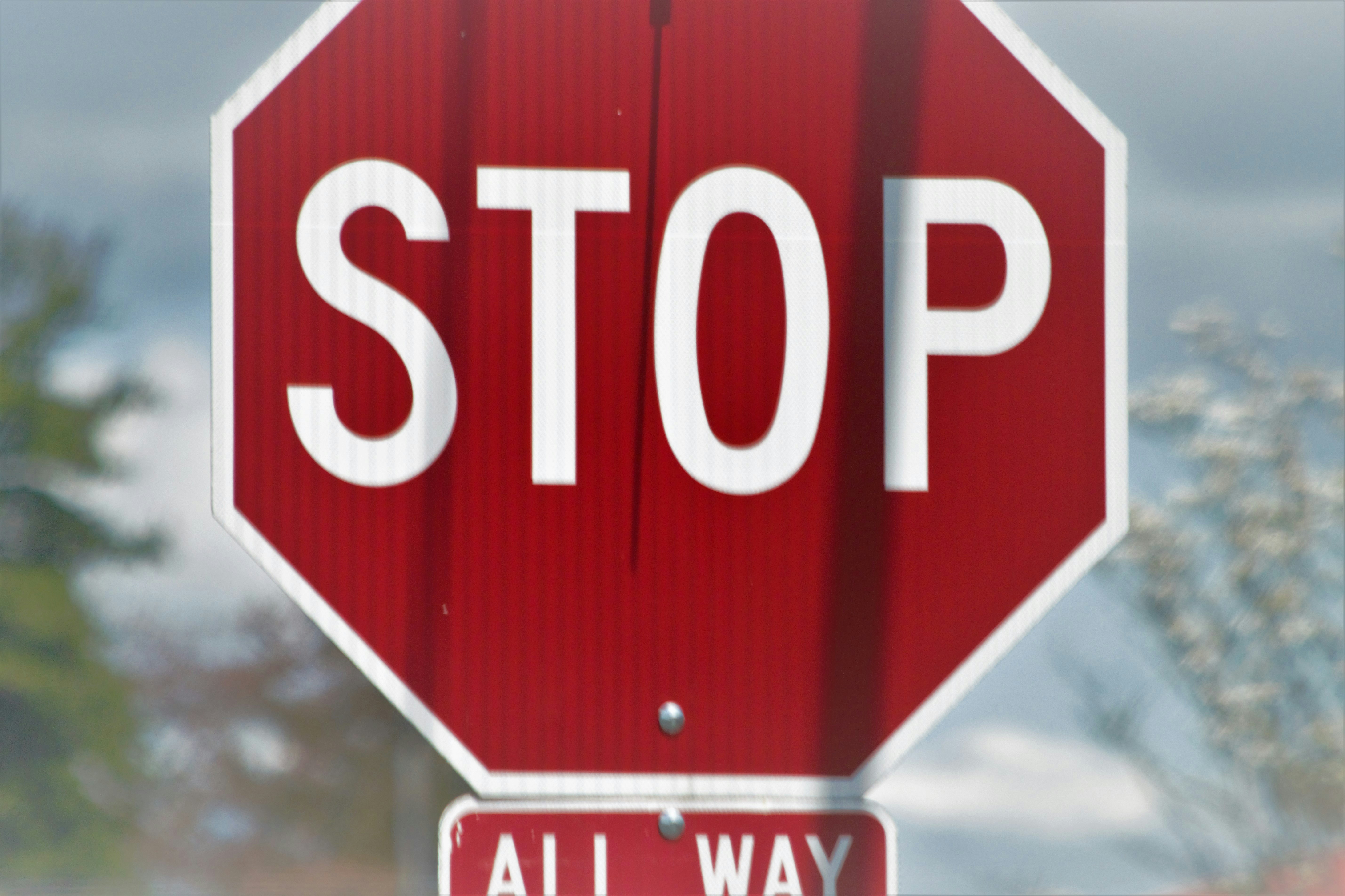 A red stop sign sitting on the side of a road photo – Free Sign Image ...