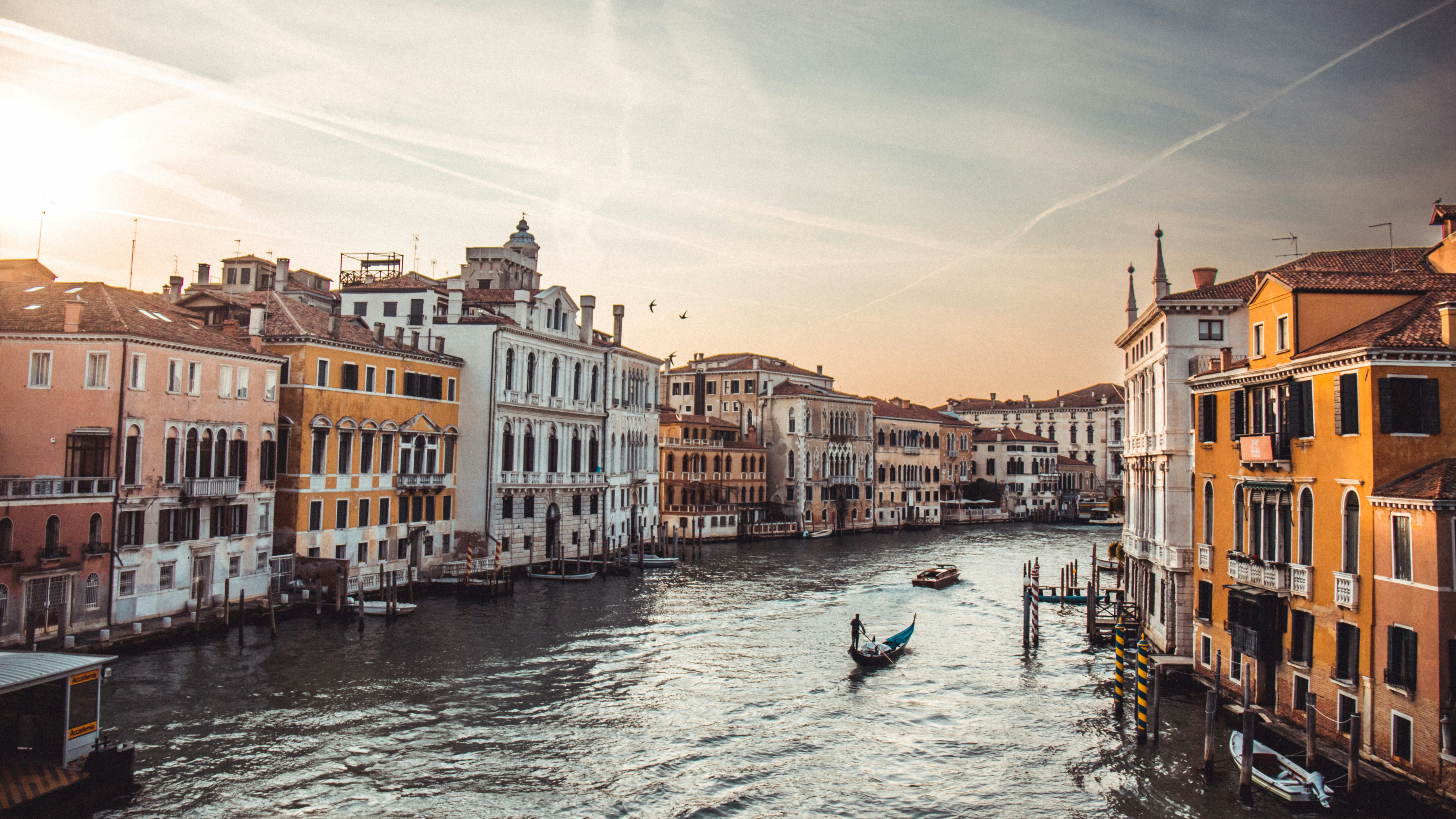 A boat traveling down a river next to tall buildings photo – Free ...