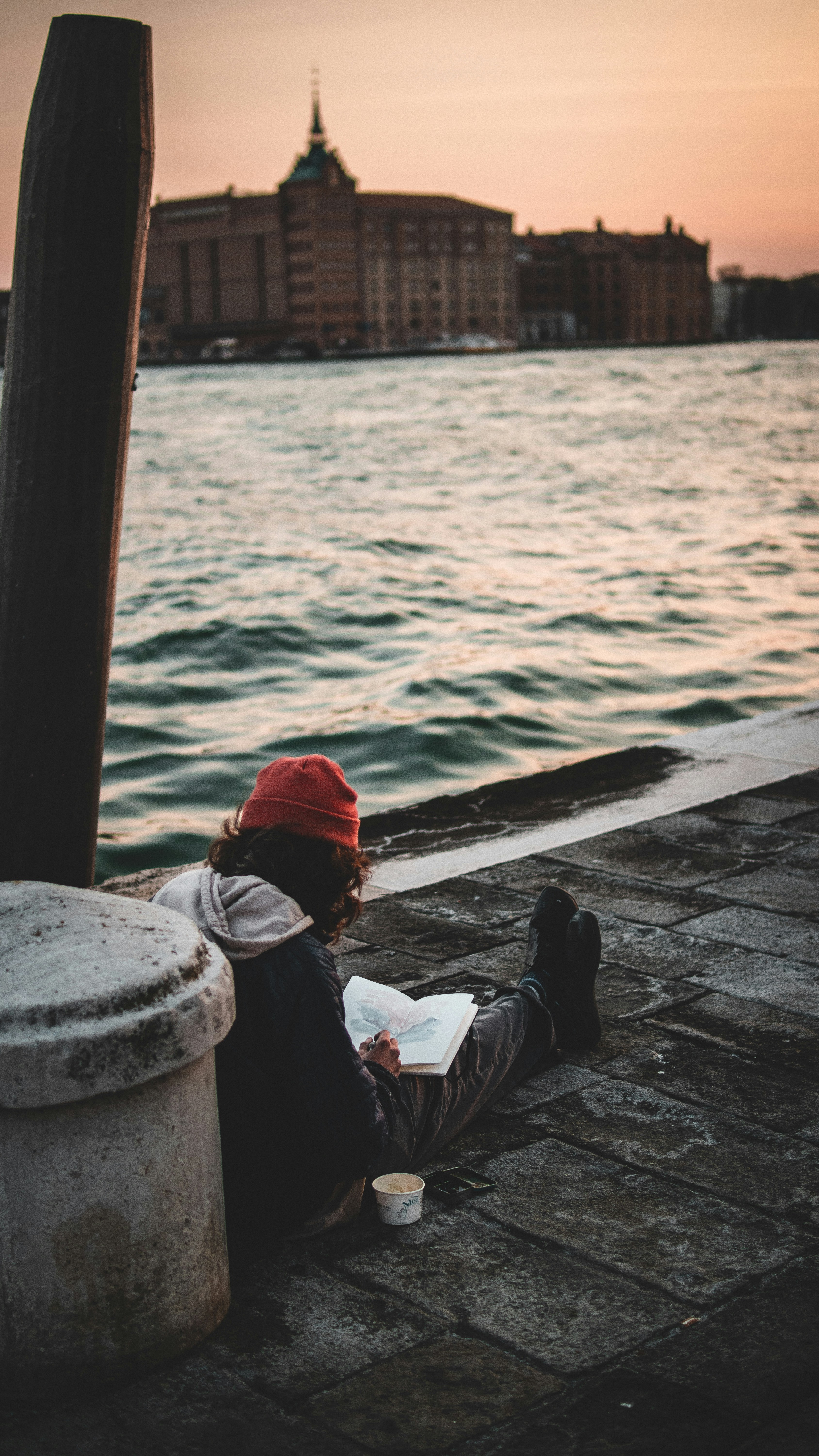 Quiet Harbor Sketch: a reader by the water at dusk