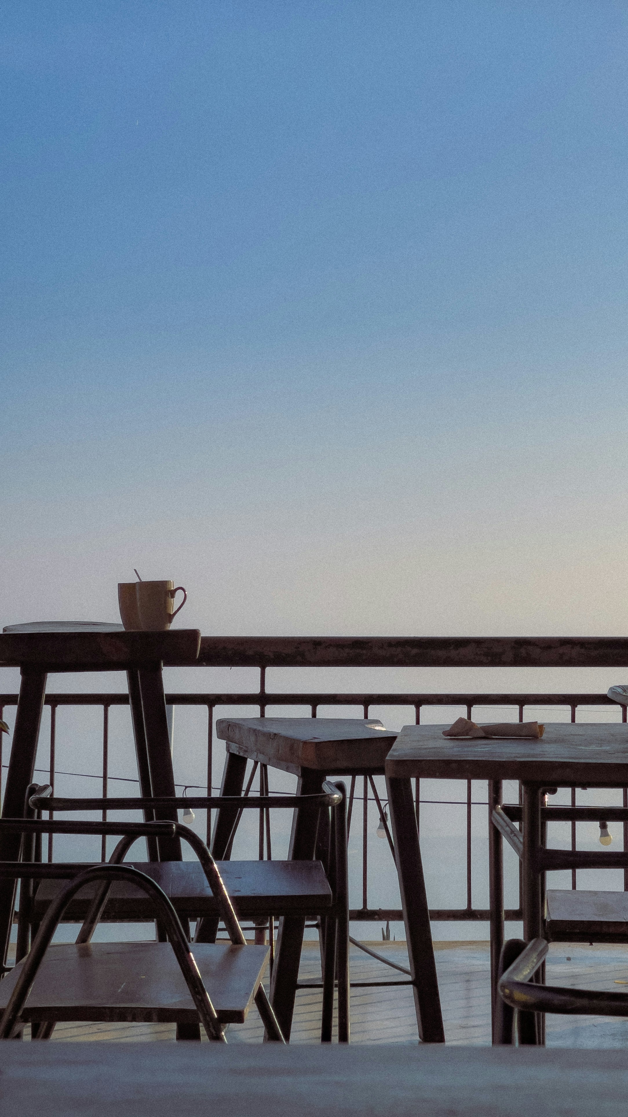 A table and chairs on a balcony overlooking the ocean photo – Free Fog ...