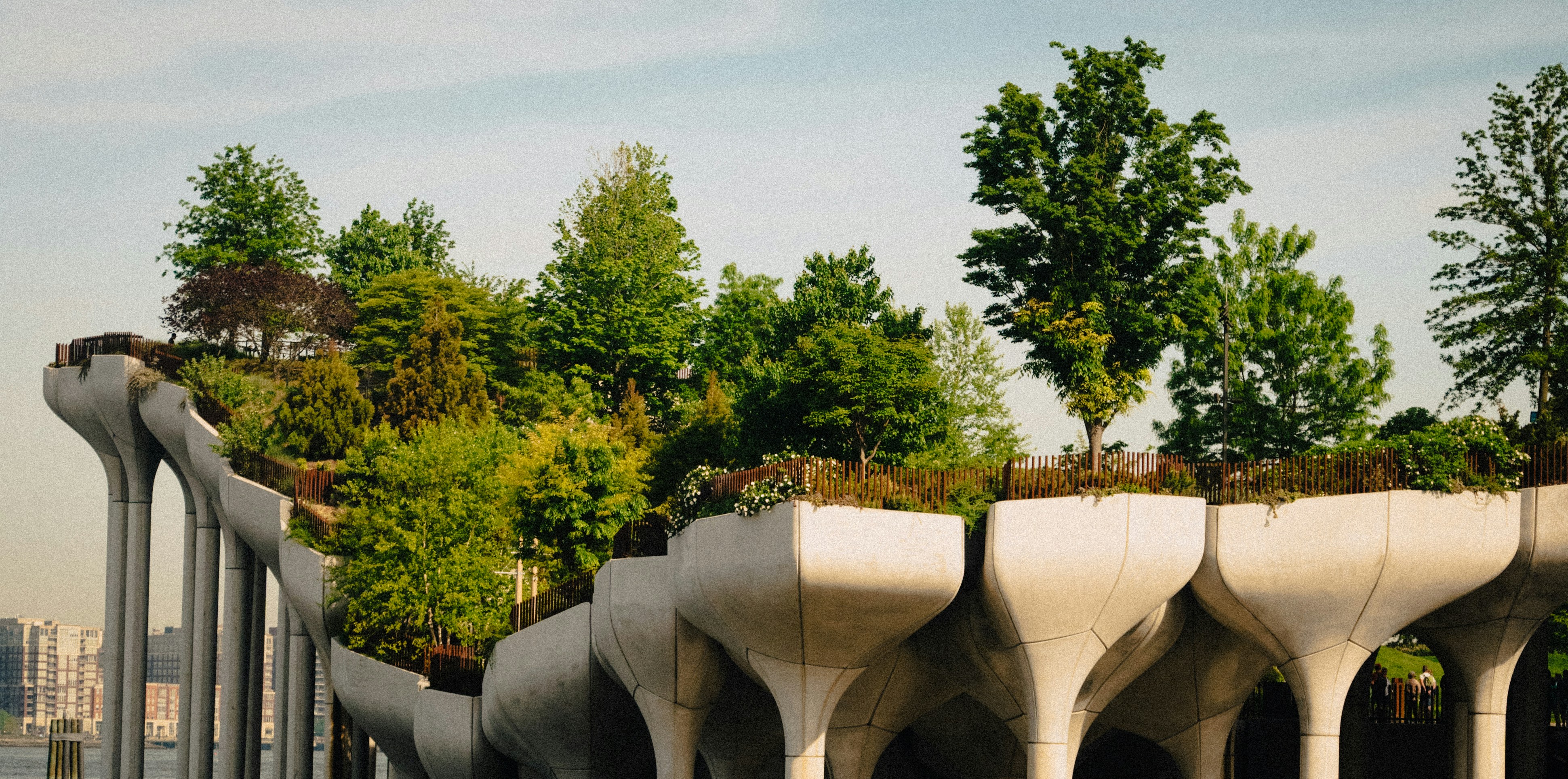 A row of concrete structures with trees in the background photo – Free ...