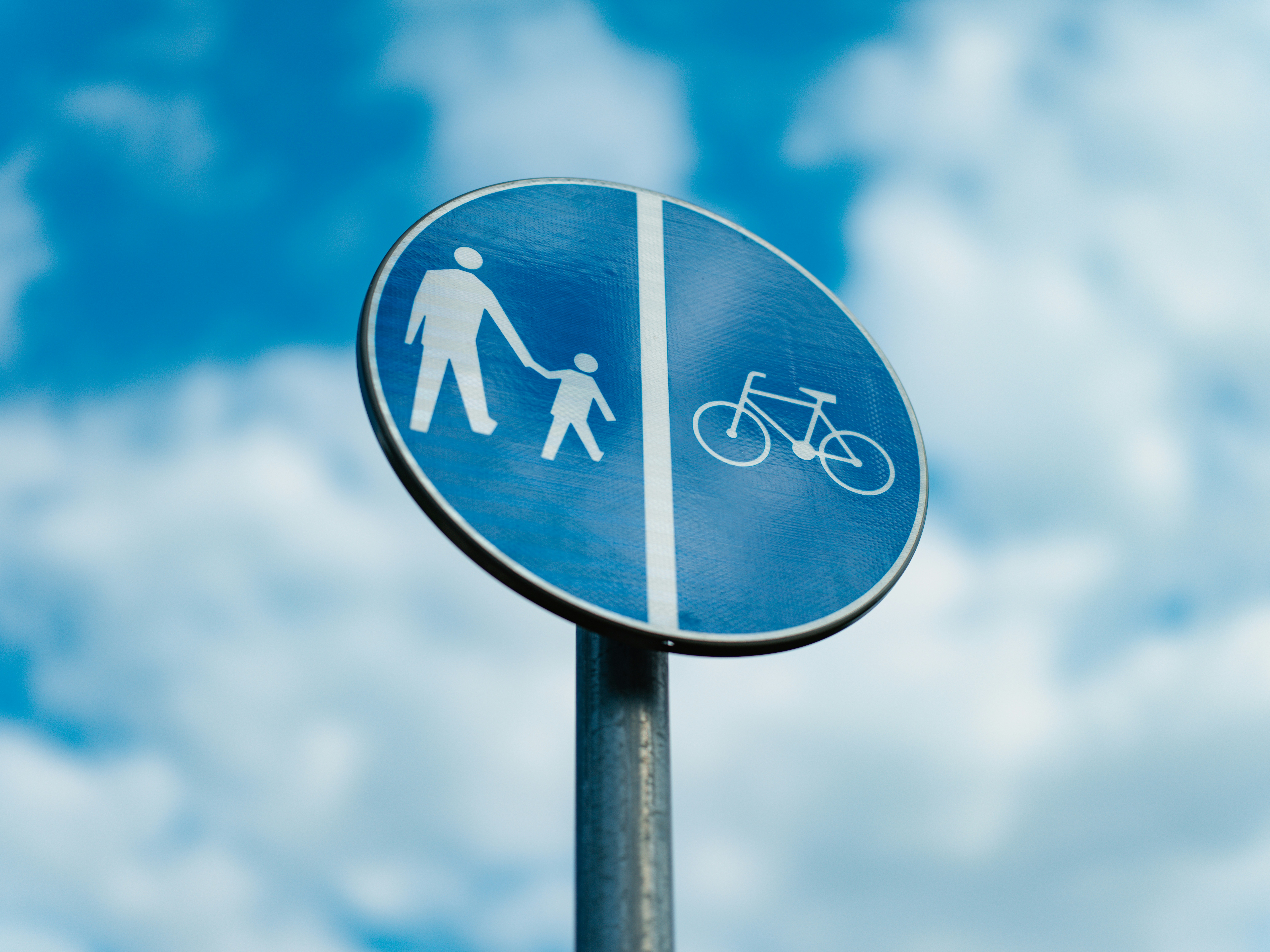 A blue street sign with a picture of a man and a woman holding hands ...