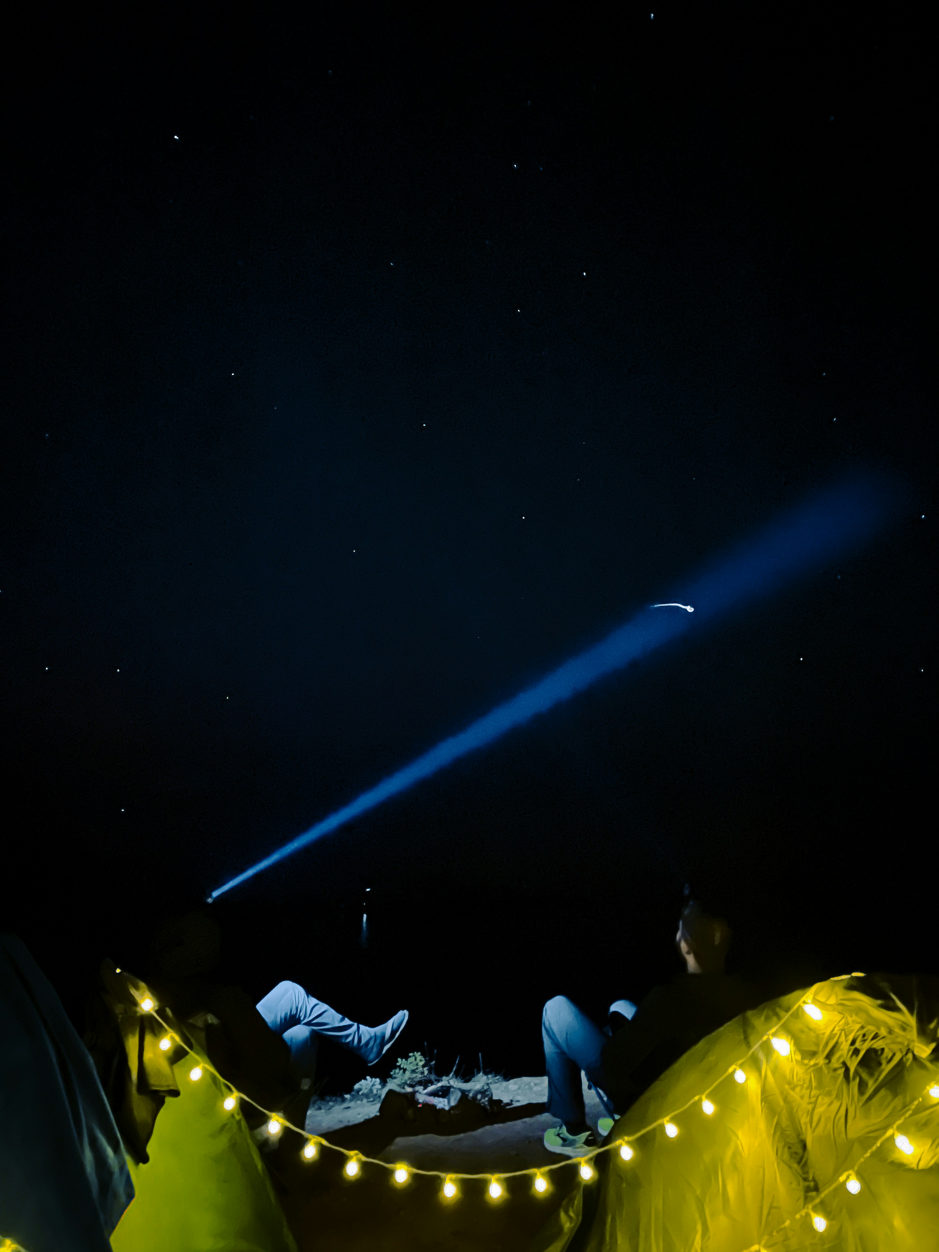 Night Crew Under a Starry Arc: a Blue Beam Across the Camp