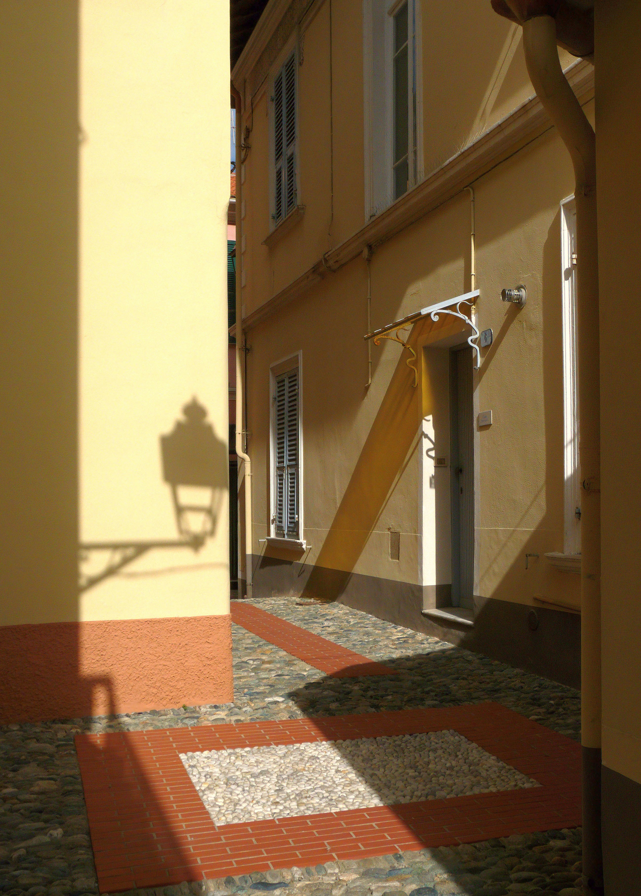 The shadow of a street light on the side of a building photo – Free ...