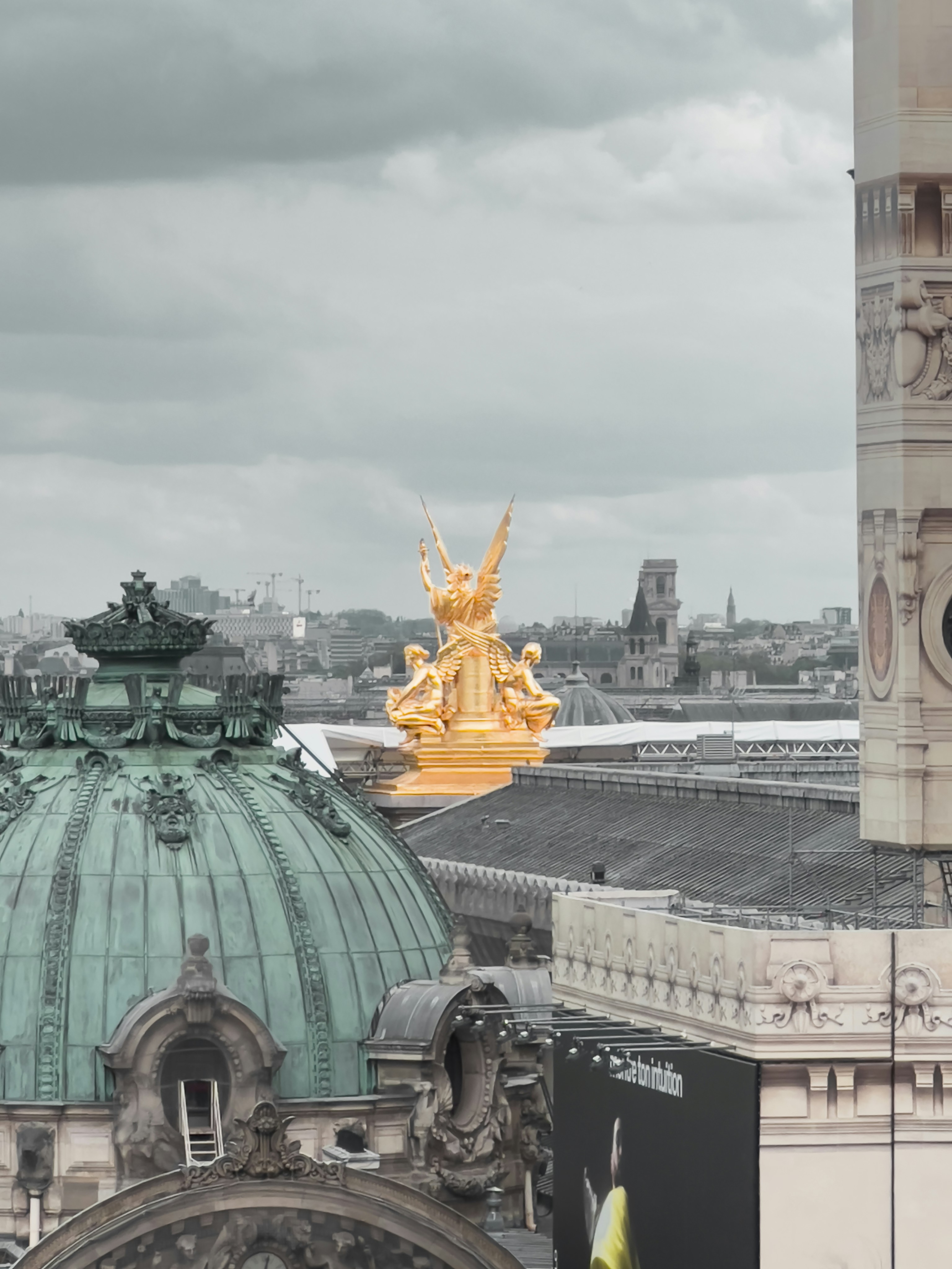 Gilded Sentinel Over a Green-Domed Cityscape