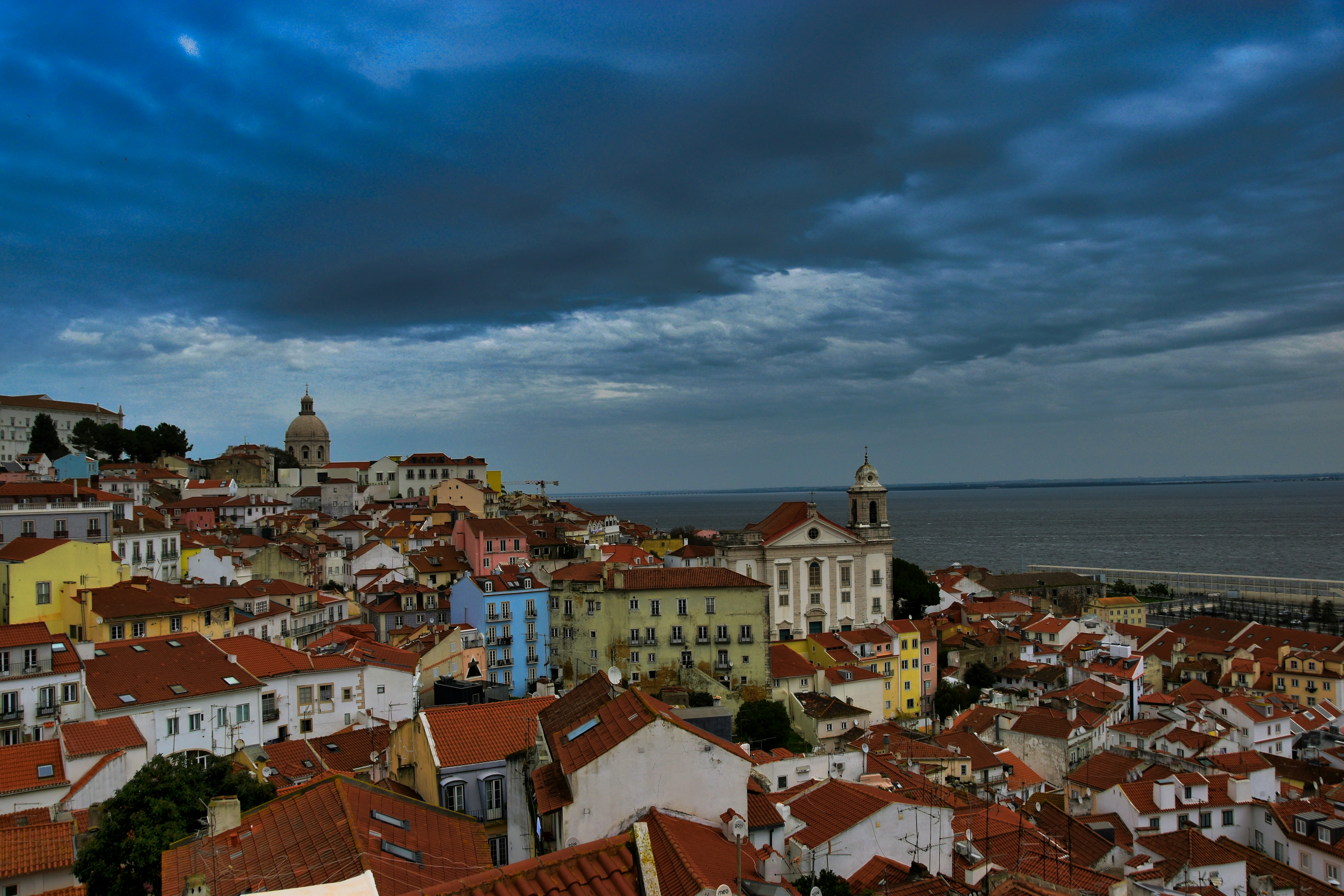 Dome-Crowned Hillside: A Colorful Coastal Town Under Stormy Skies