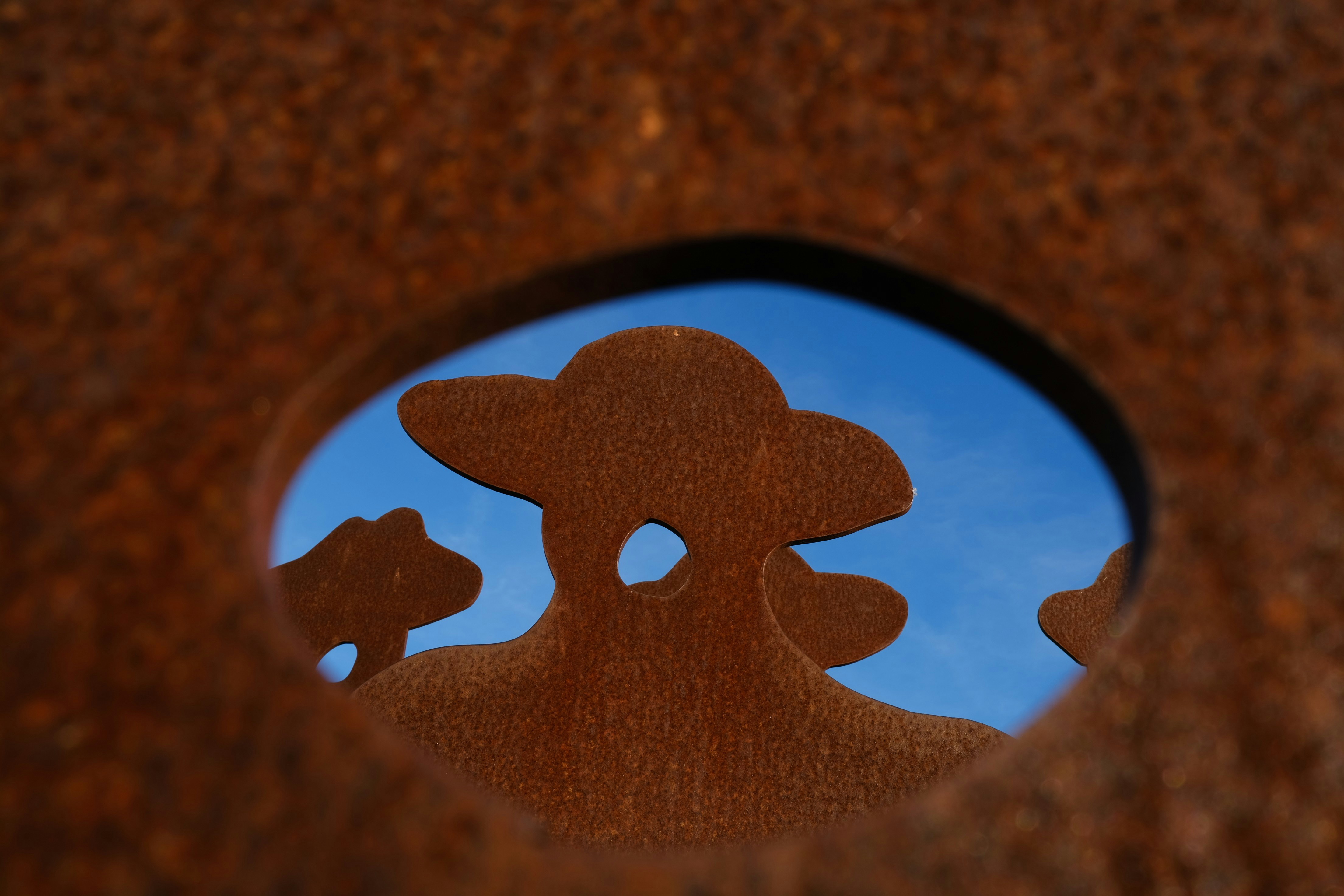 Rusty Circular Window: Sky Framed by Corrosion