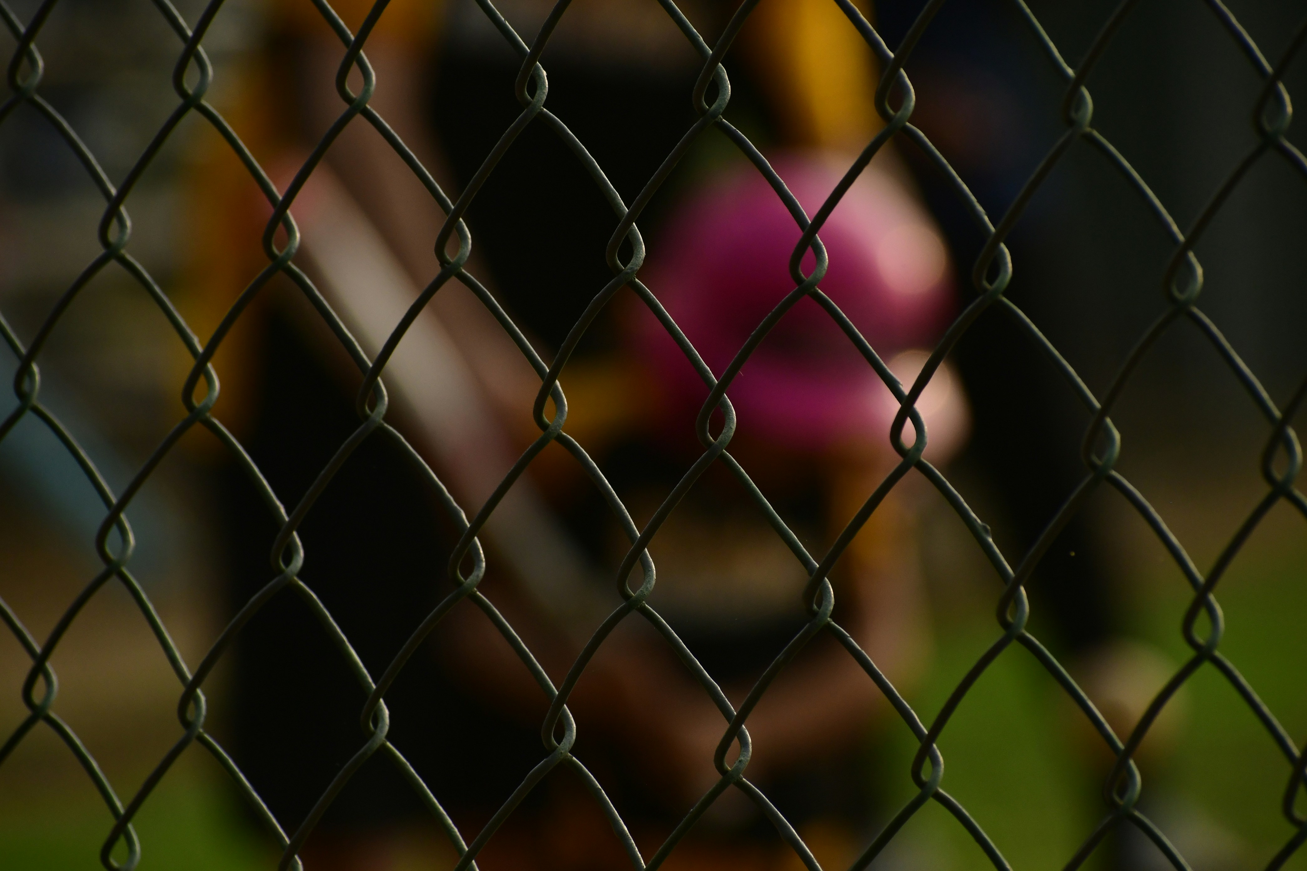 Through the Mesh: A Quiet Playground Framed by Chain-Link