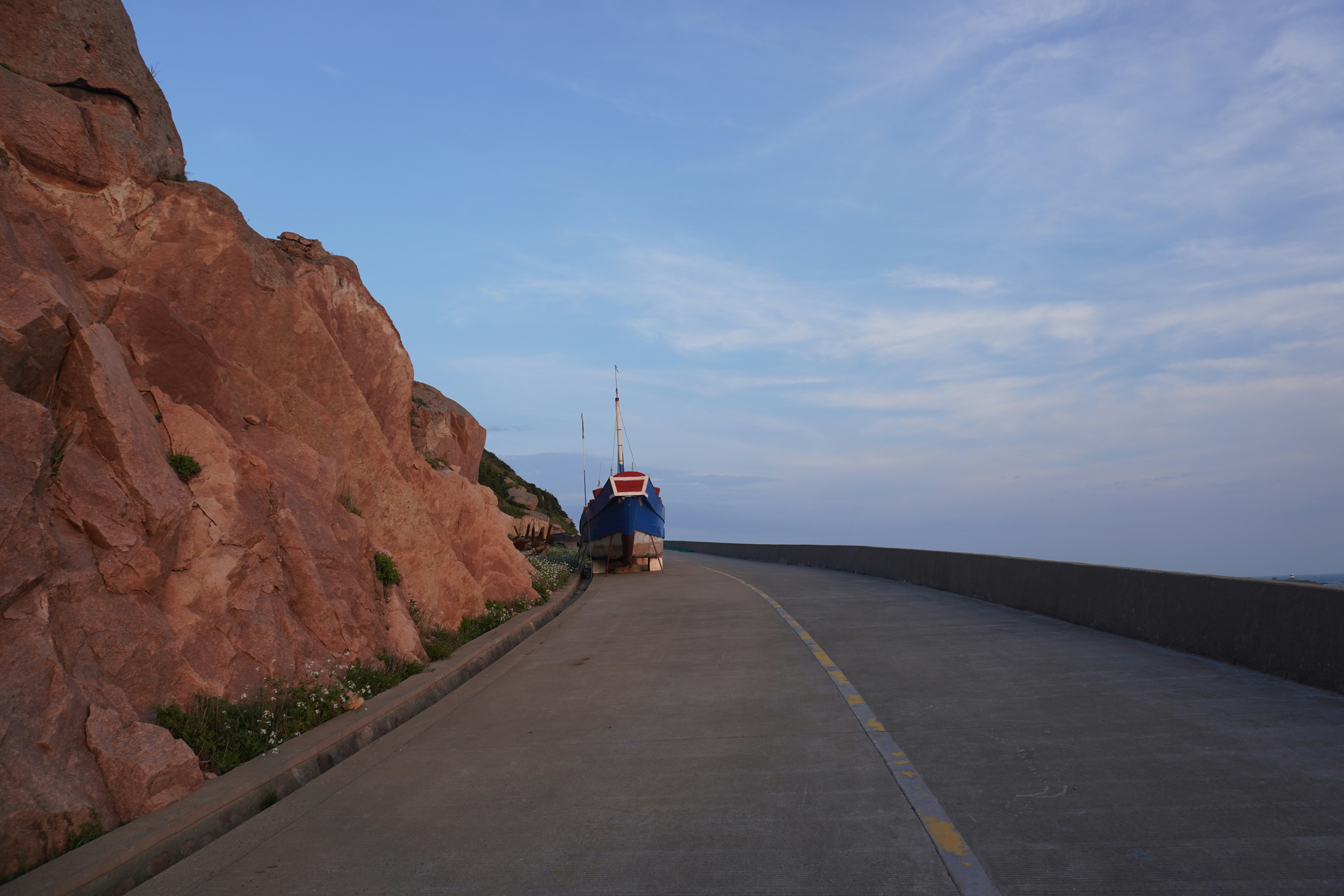 Blue Vessel at the Cliffside Promenade: A Quiet Walk Toward the Sea