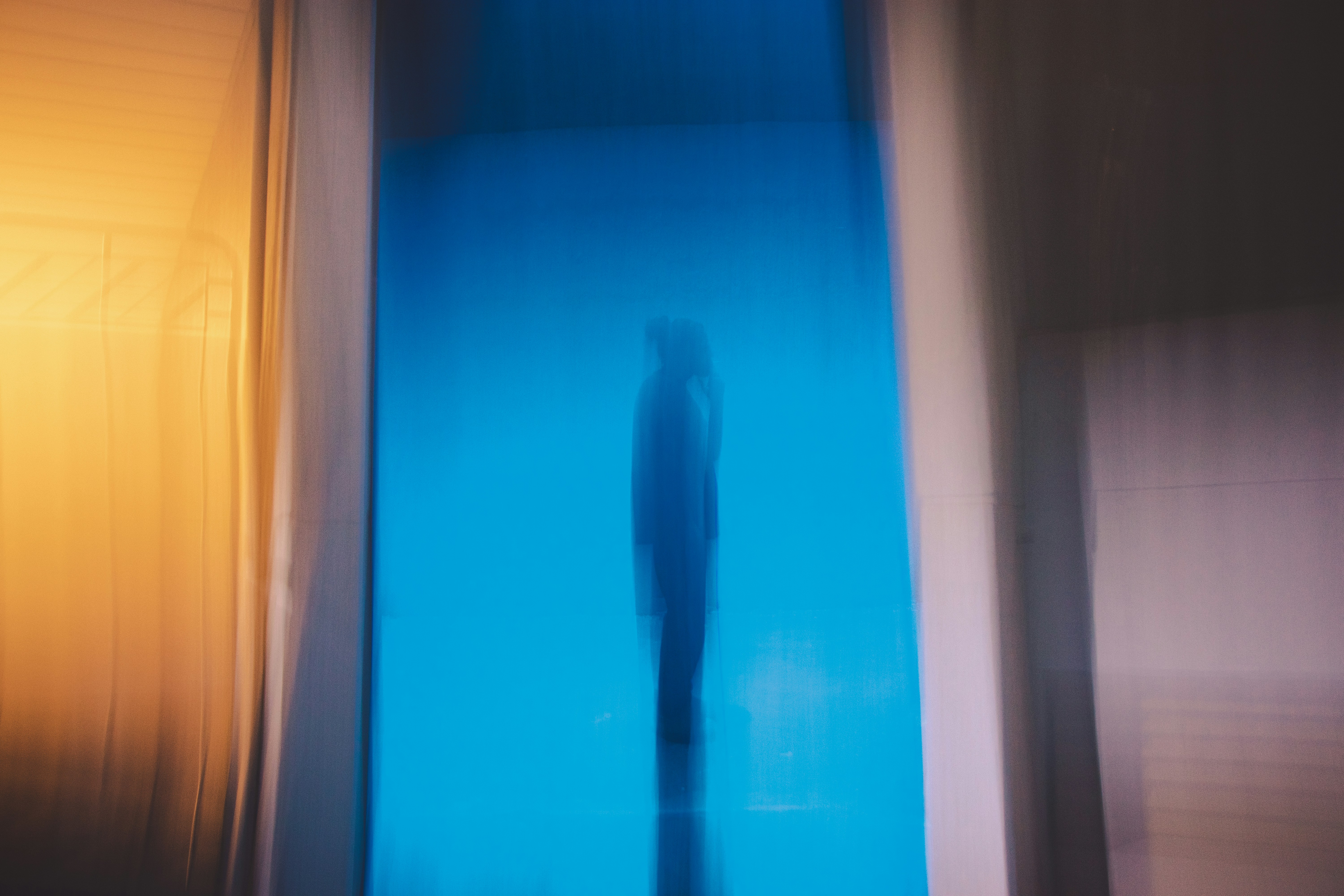 Echo in Color: A Silhouetted Figure Within a Neon Corridor