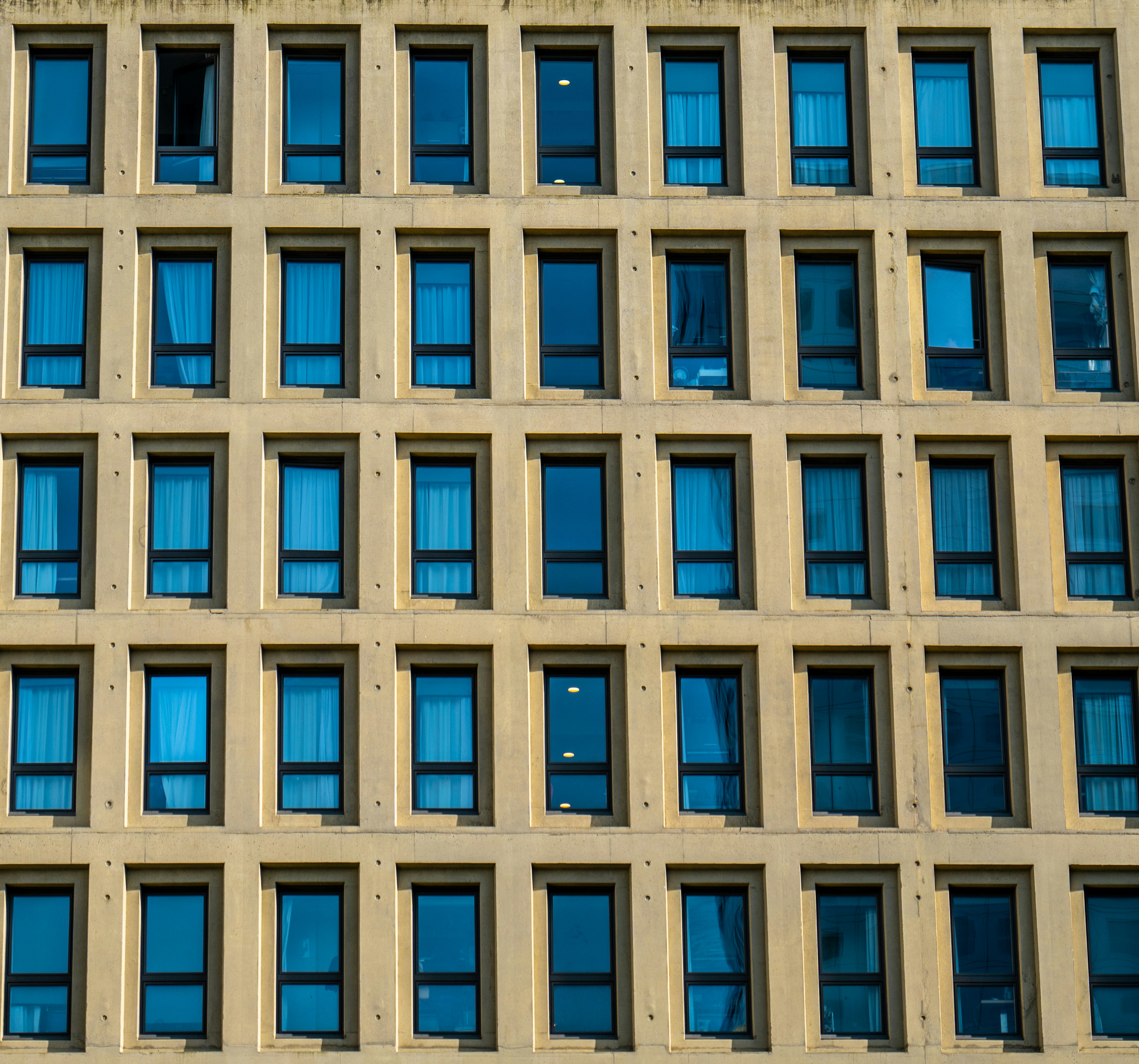 Modern building facade with a grid of blue-tinted windows in Nantes.