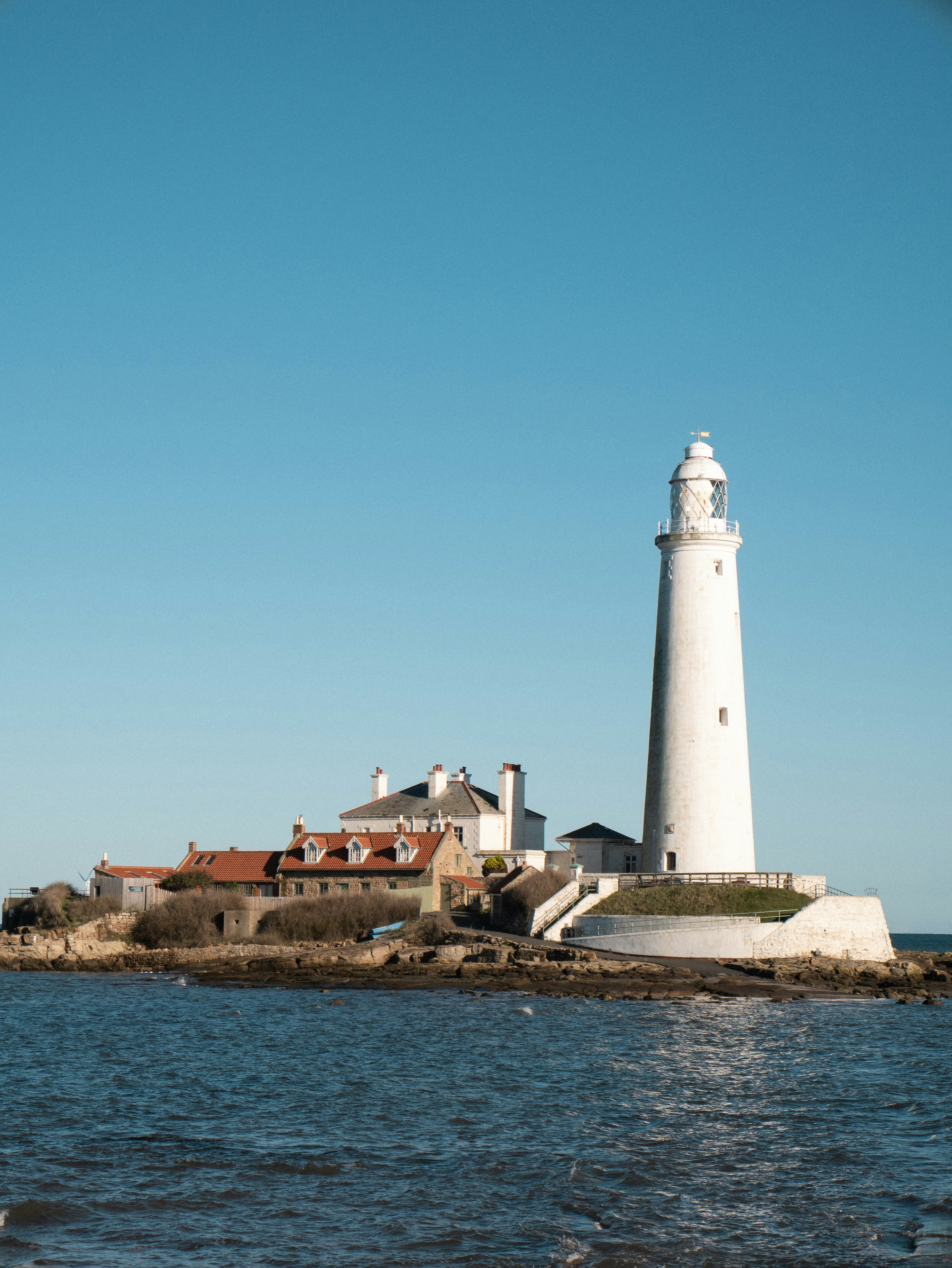 Un faro en una pequeña isla en medio del océano foto – Imagen de Faro ...