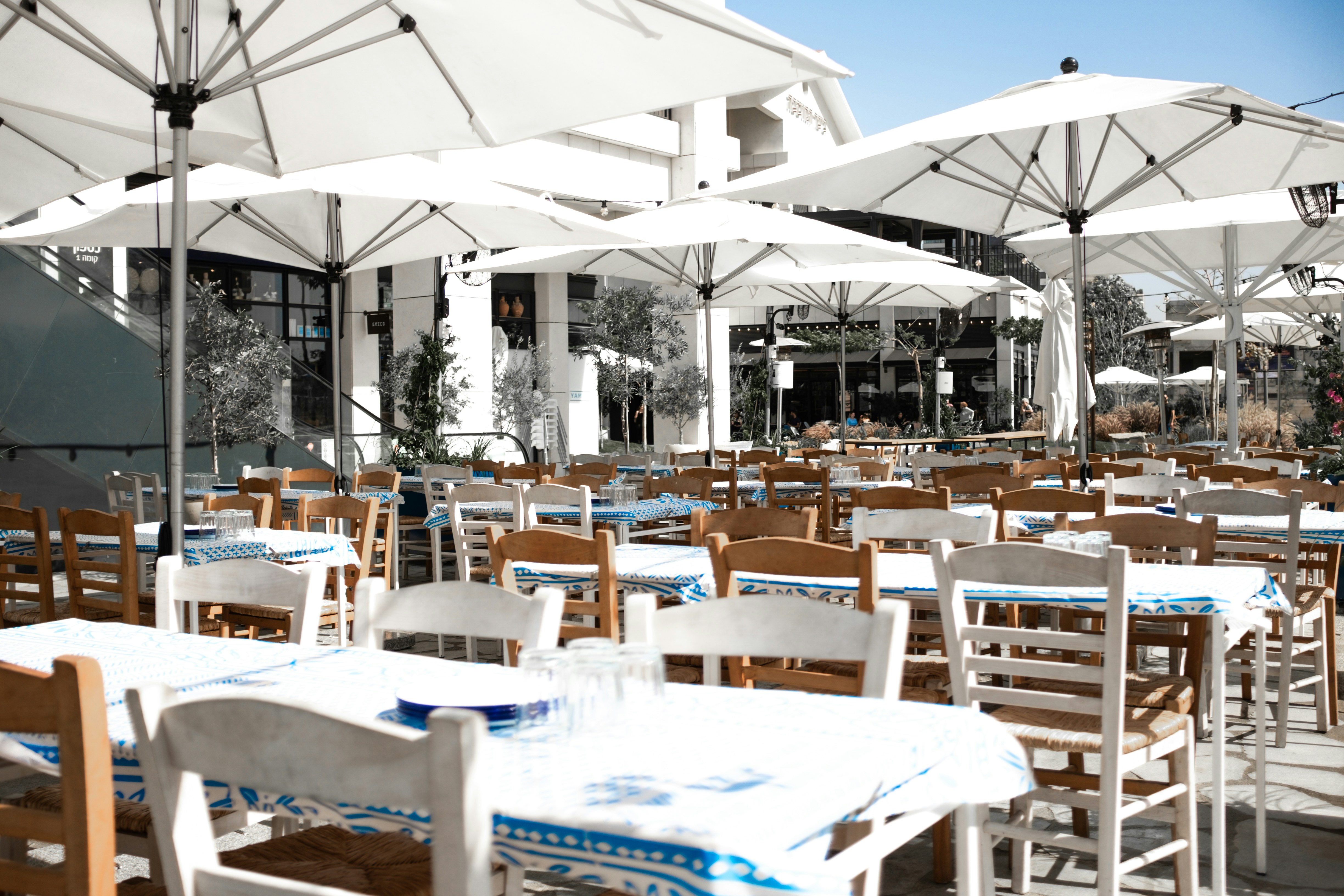 Une salle à manger extérieure avec tables et parasols photo – Photo ...