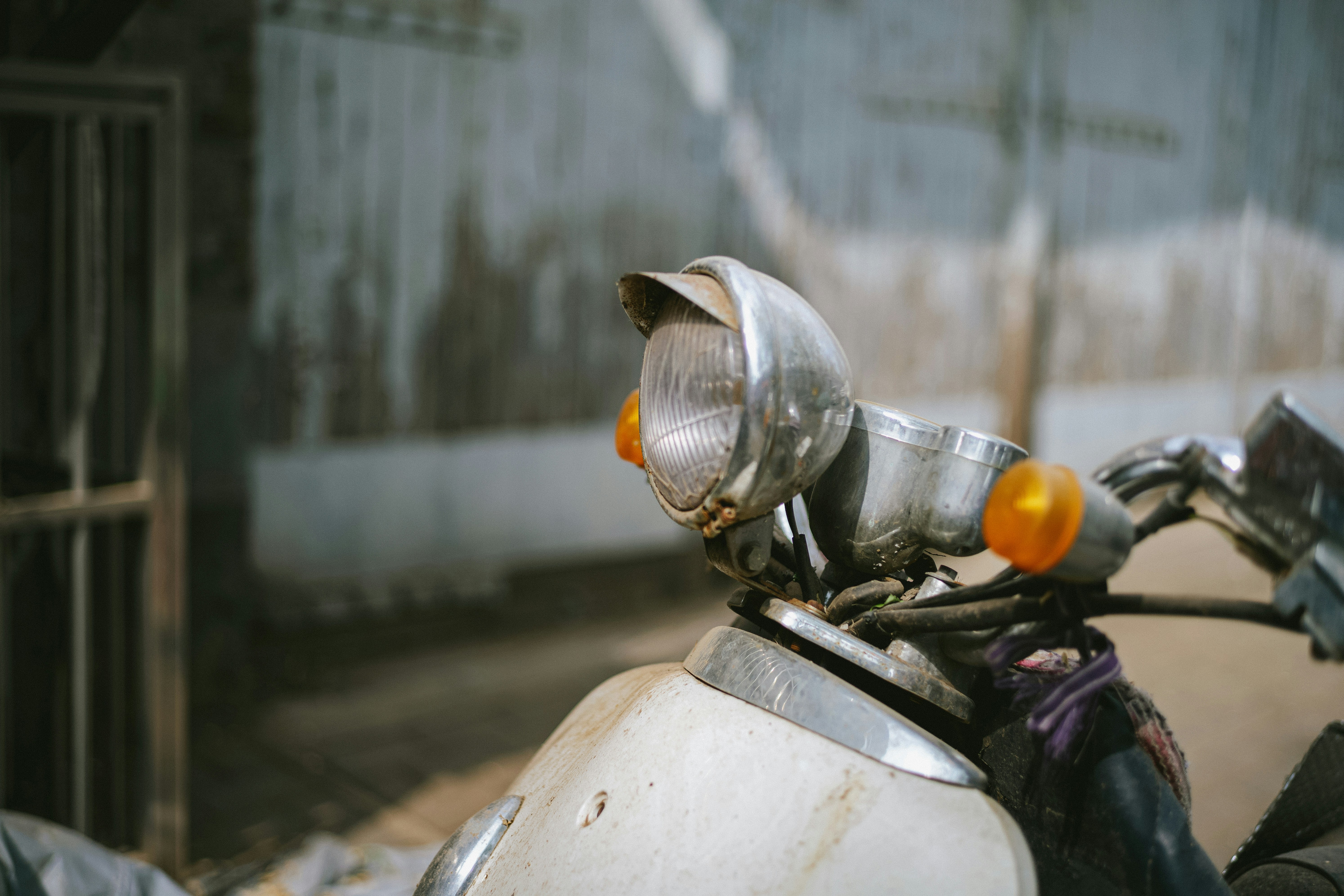 Patina Glow: Weathered Headlamp in a Rain-Washed Alley