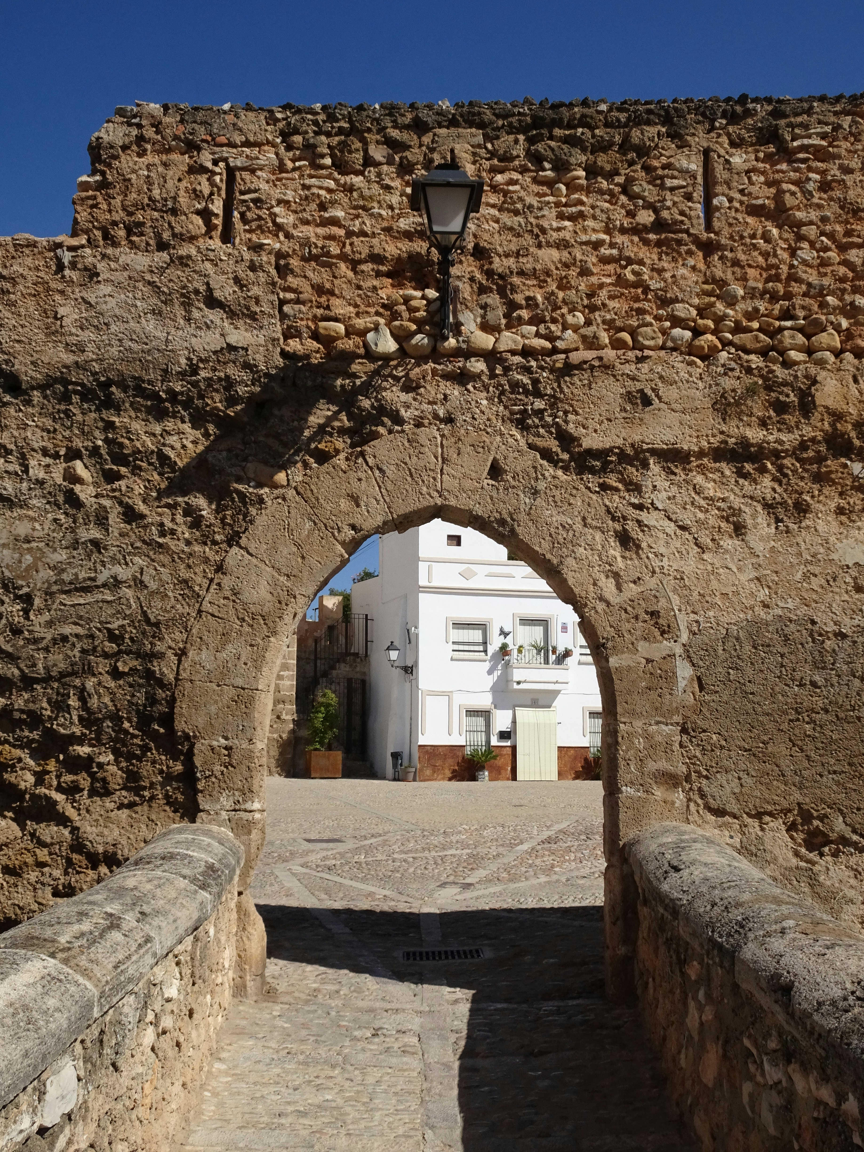 a stone wall with a light on top of it