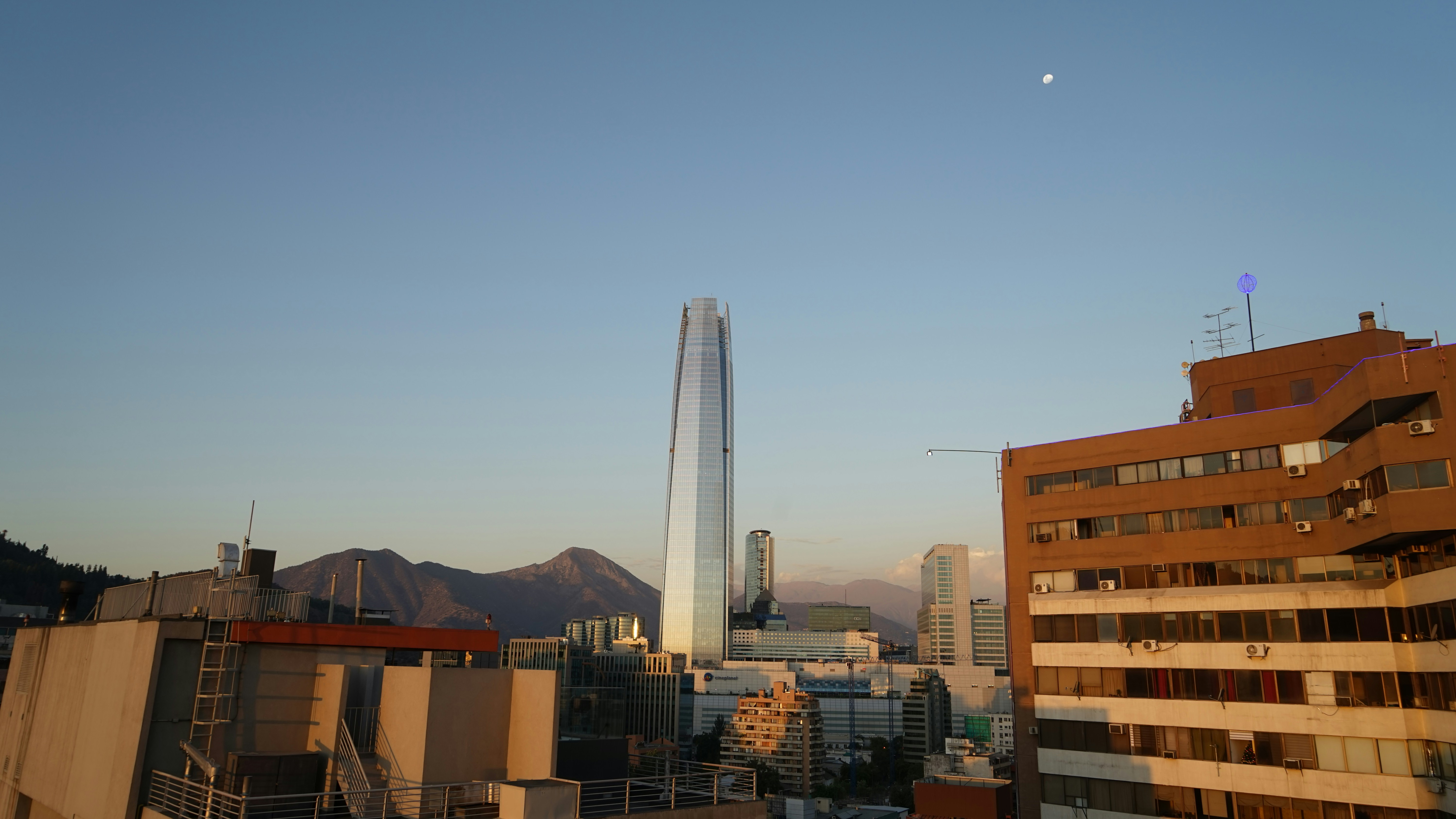 Glass Spire Over a Mountain-Backed Cityscape