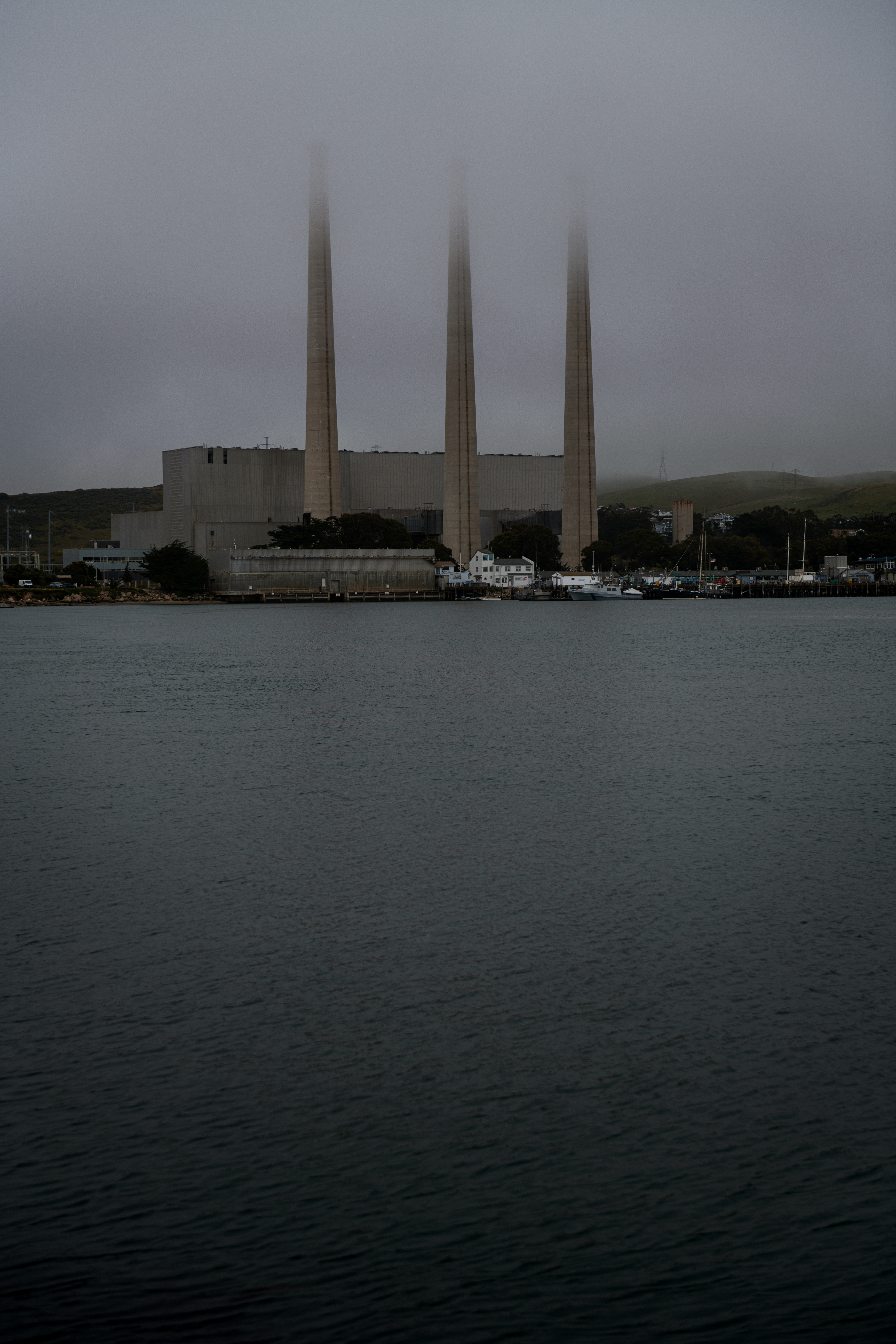 Three Fog-Draped Smokestacks Framing a Quiet Harbor