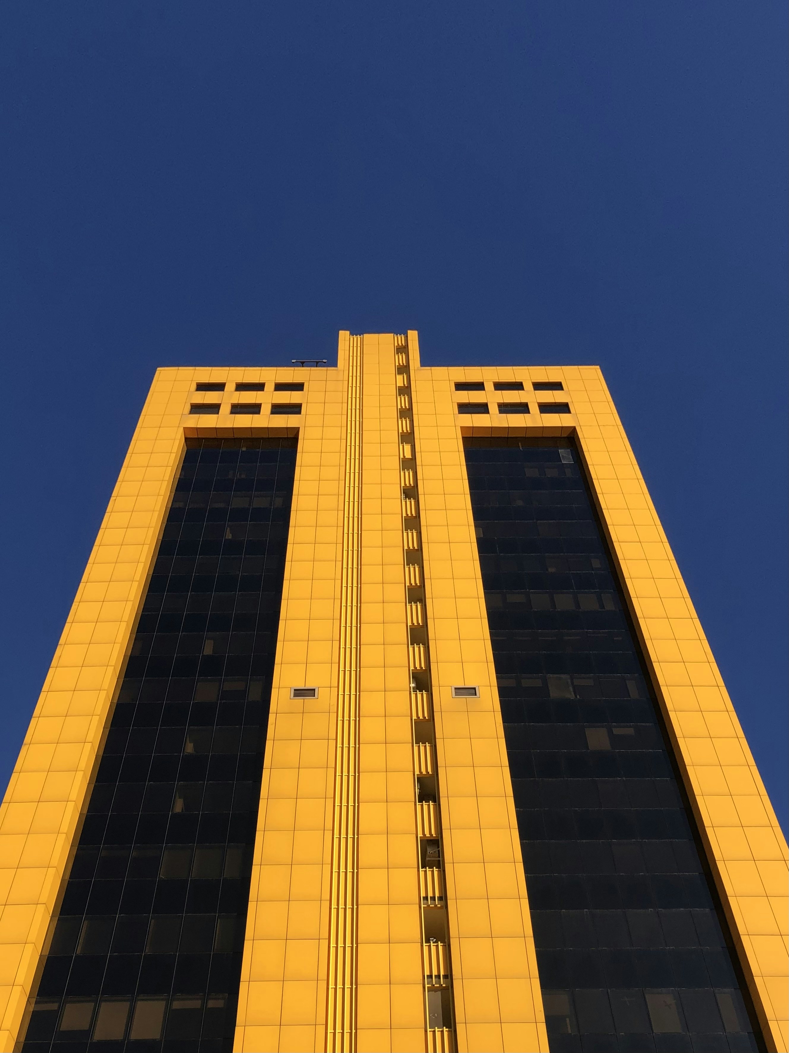 Yellow building | a tall building with a clock on the side of it