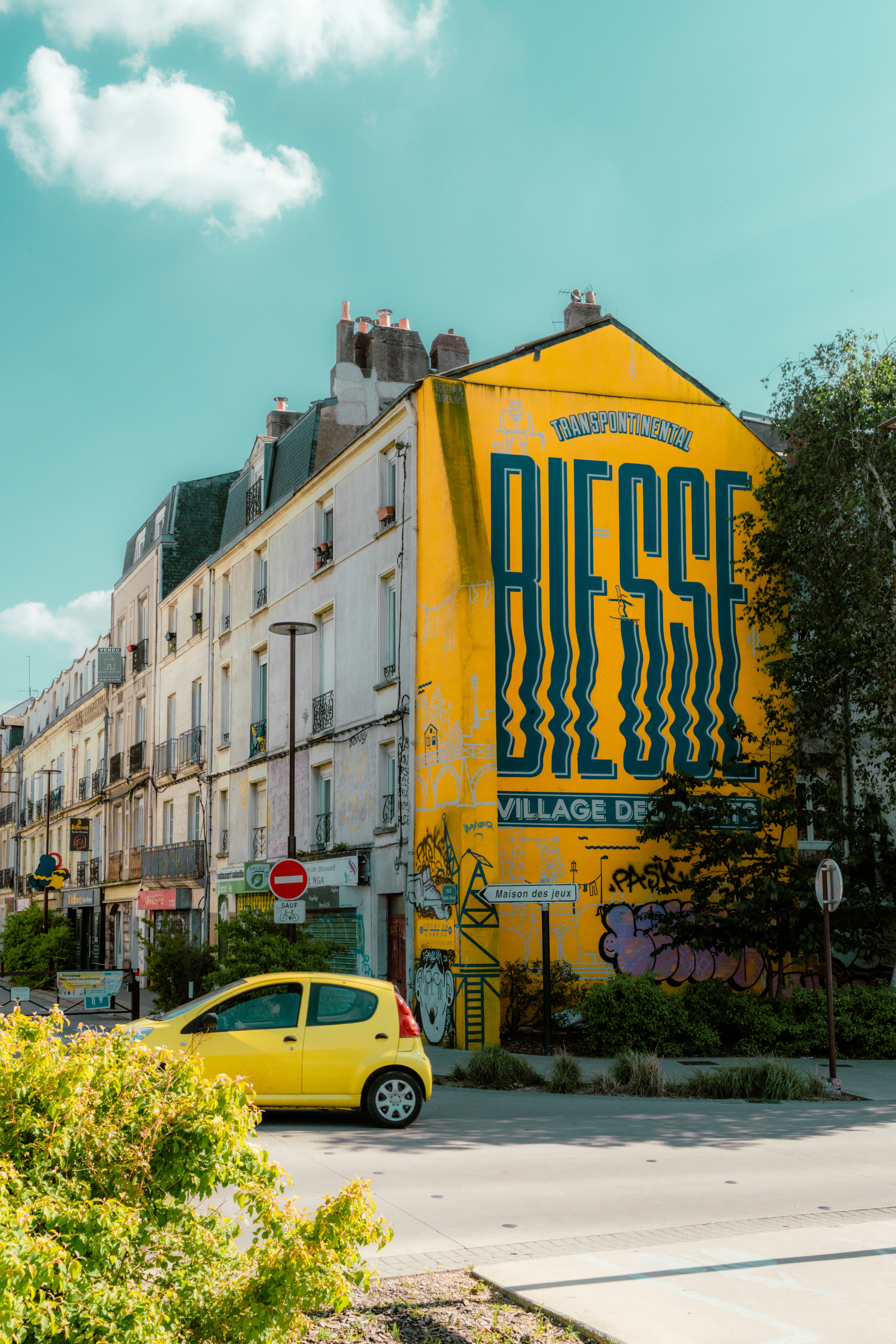 Yellow mural on a lively Parisian street corner