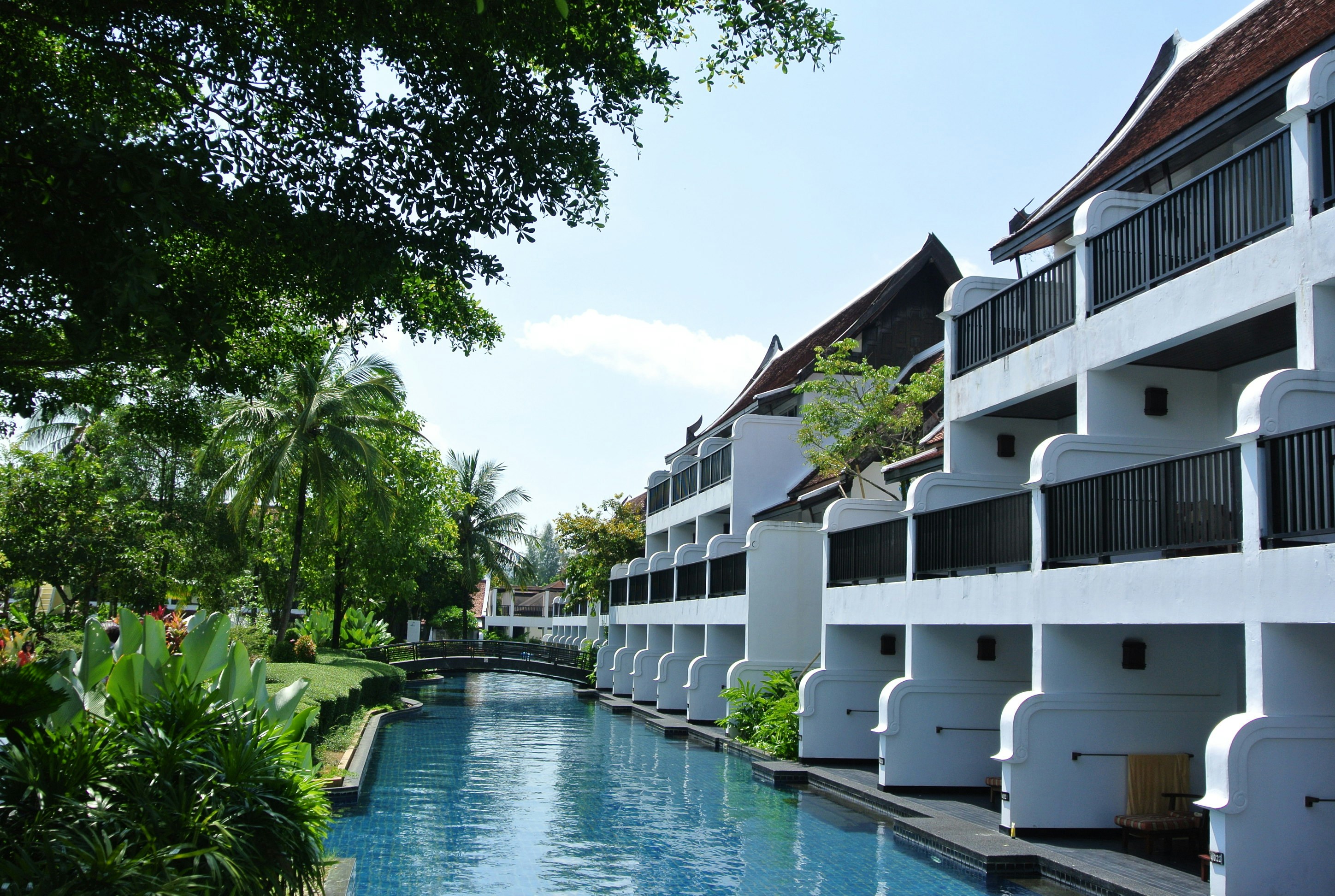 A pool in front of a row of white buildings photo – Free Hotel Image on ...