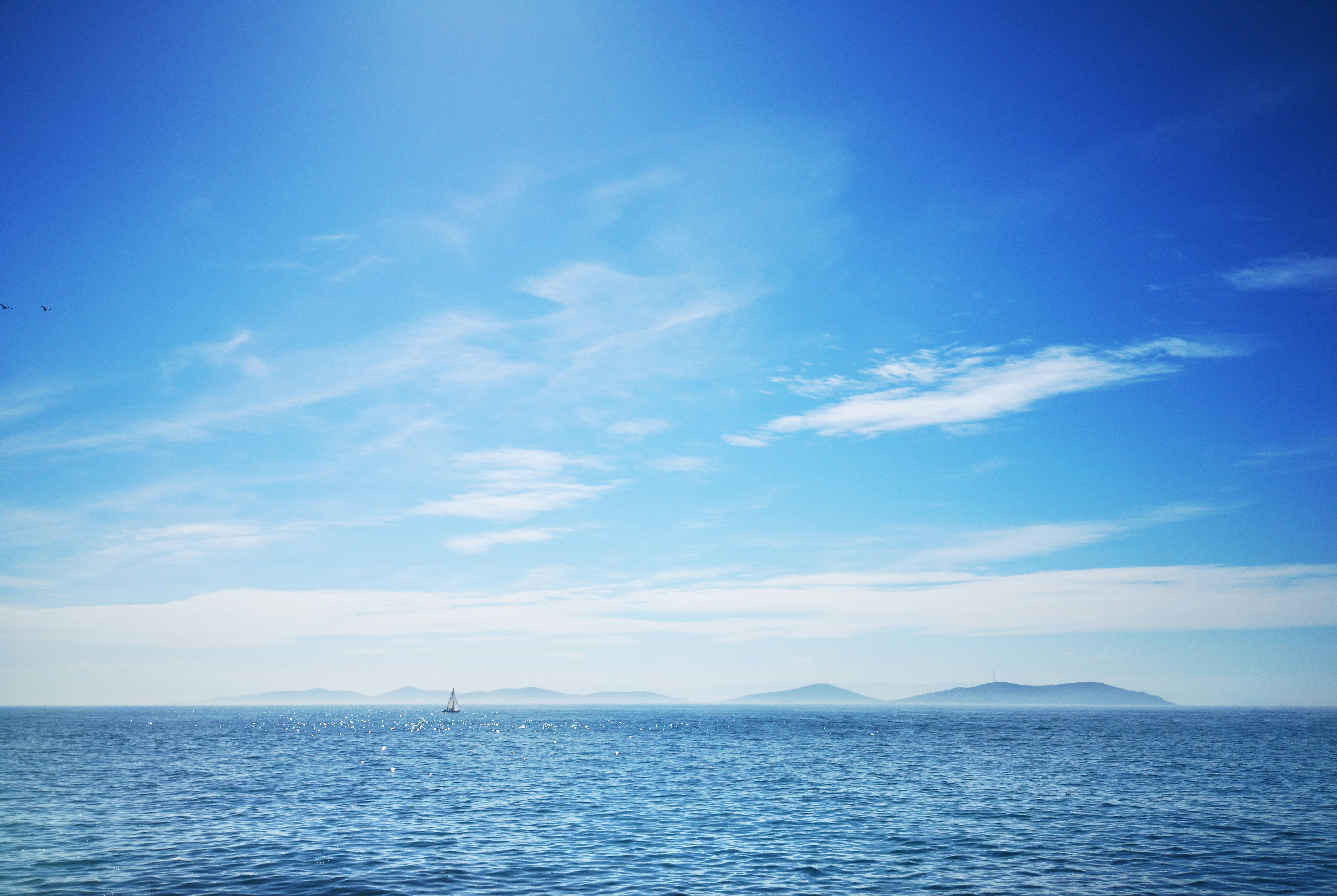 A large body of water under a blue sky photo – Free Sky Image on Unsplash