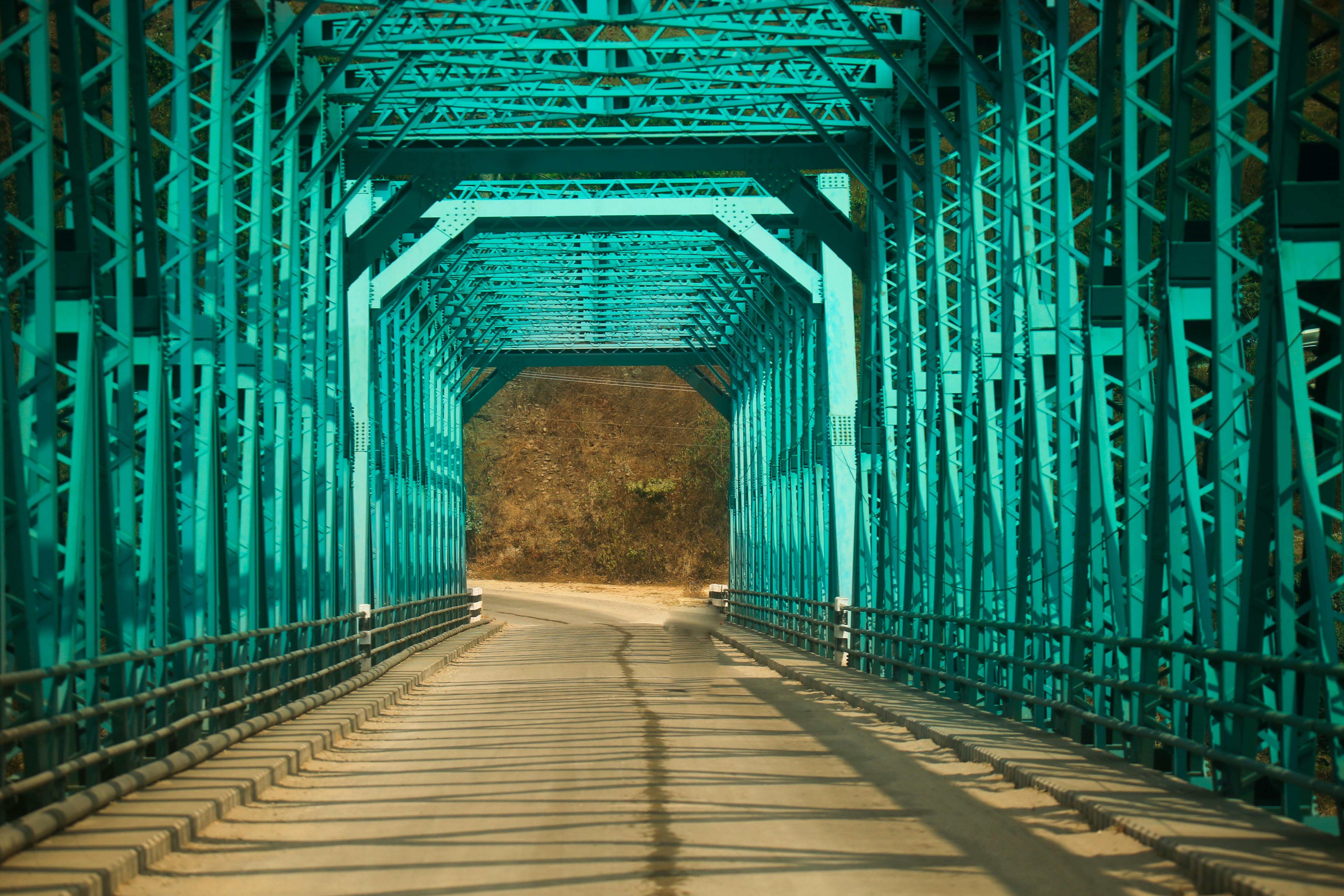 Teal Arches: A Sunlit Walk Through a Glowing Bridge