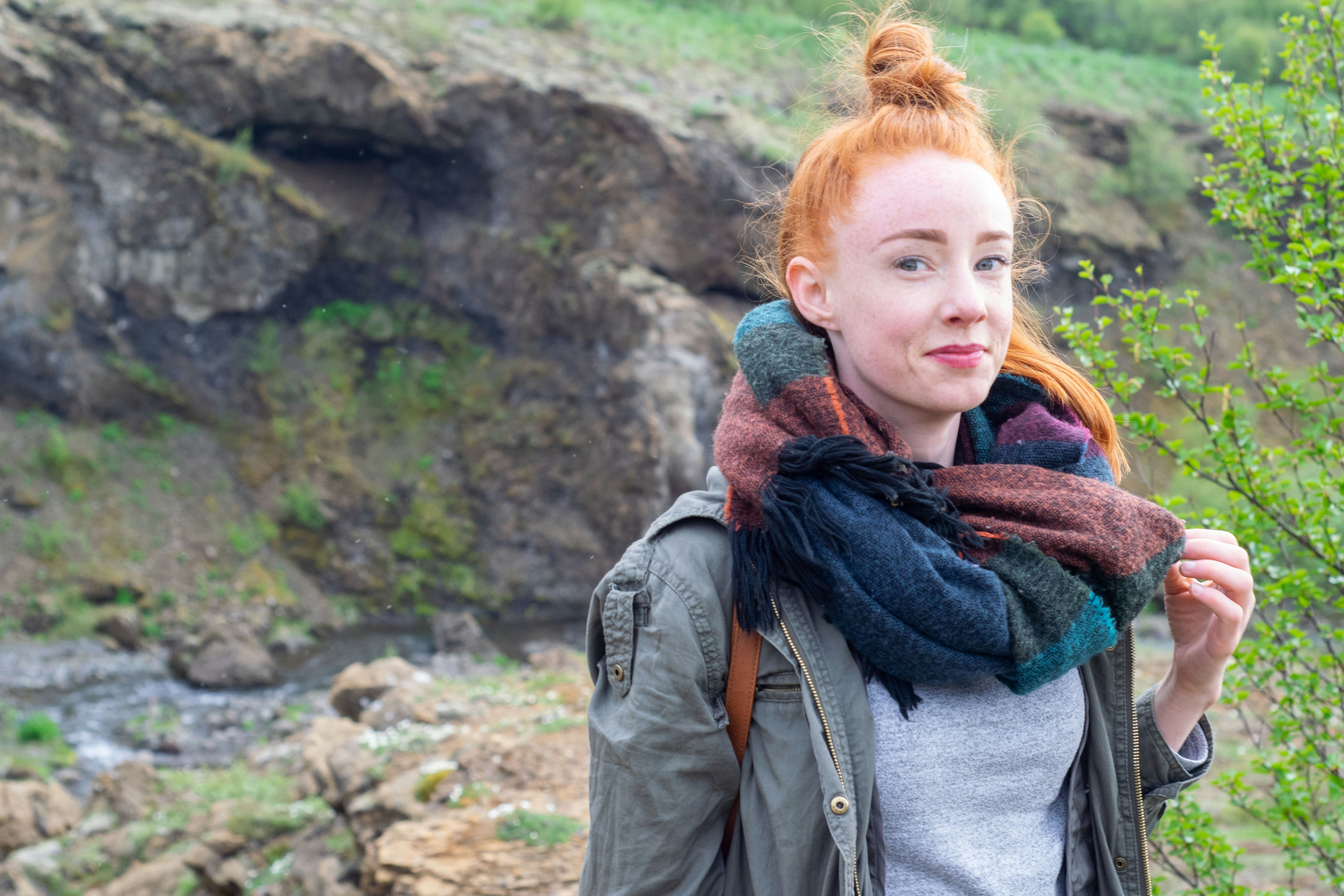 Scarlet-Haired Explorer Amid Mossy Rocks and Emerald Foliage