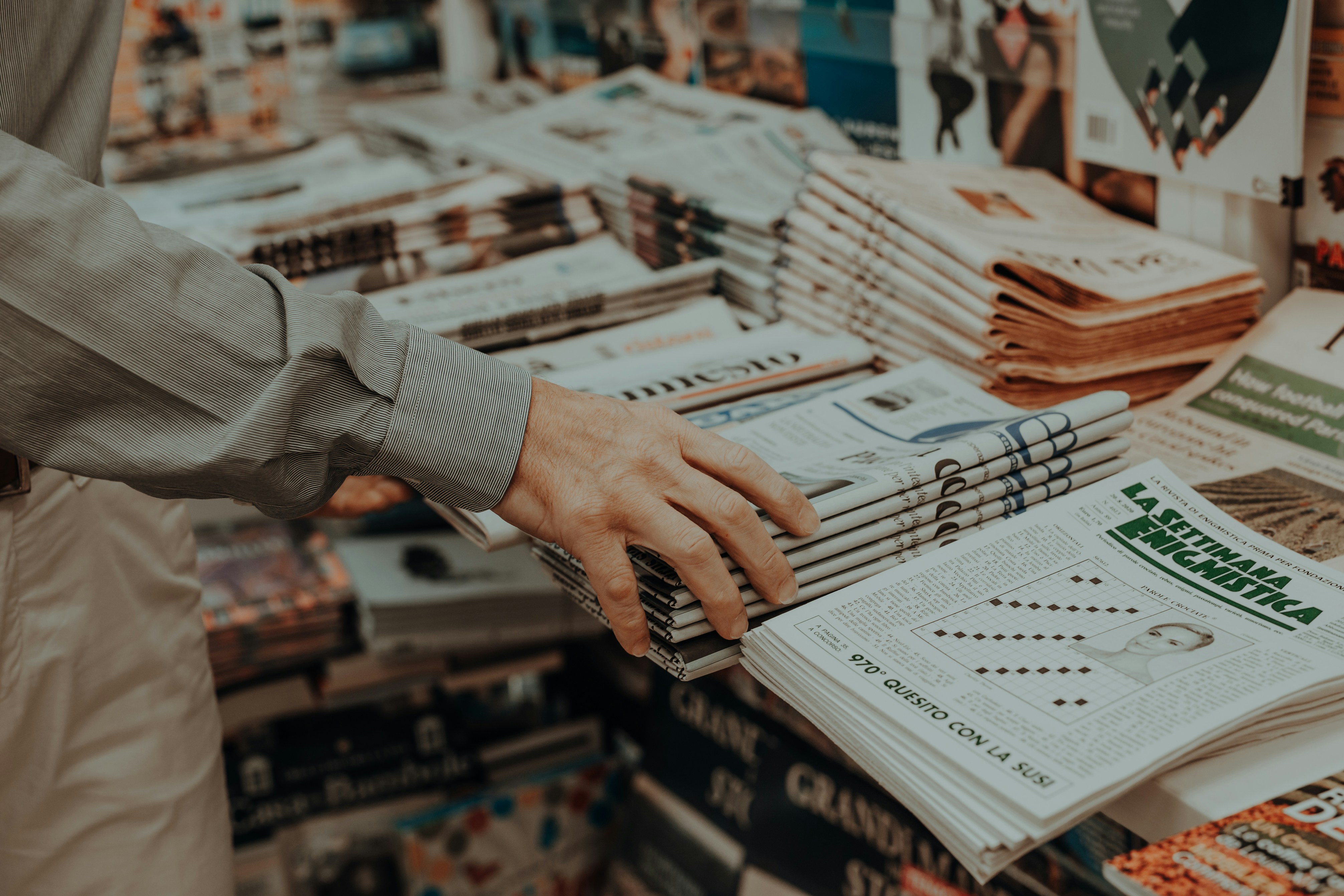 A person is holding a stack of magazines photo – Free Working man Image ...