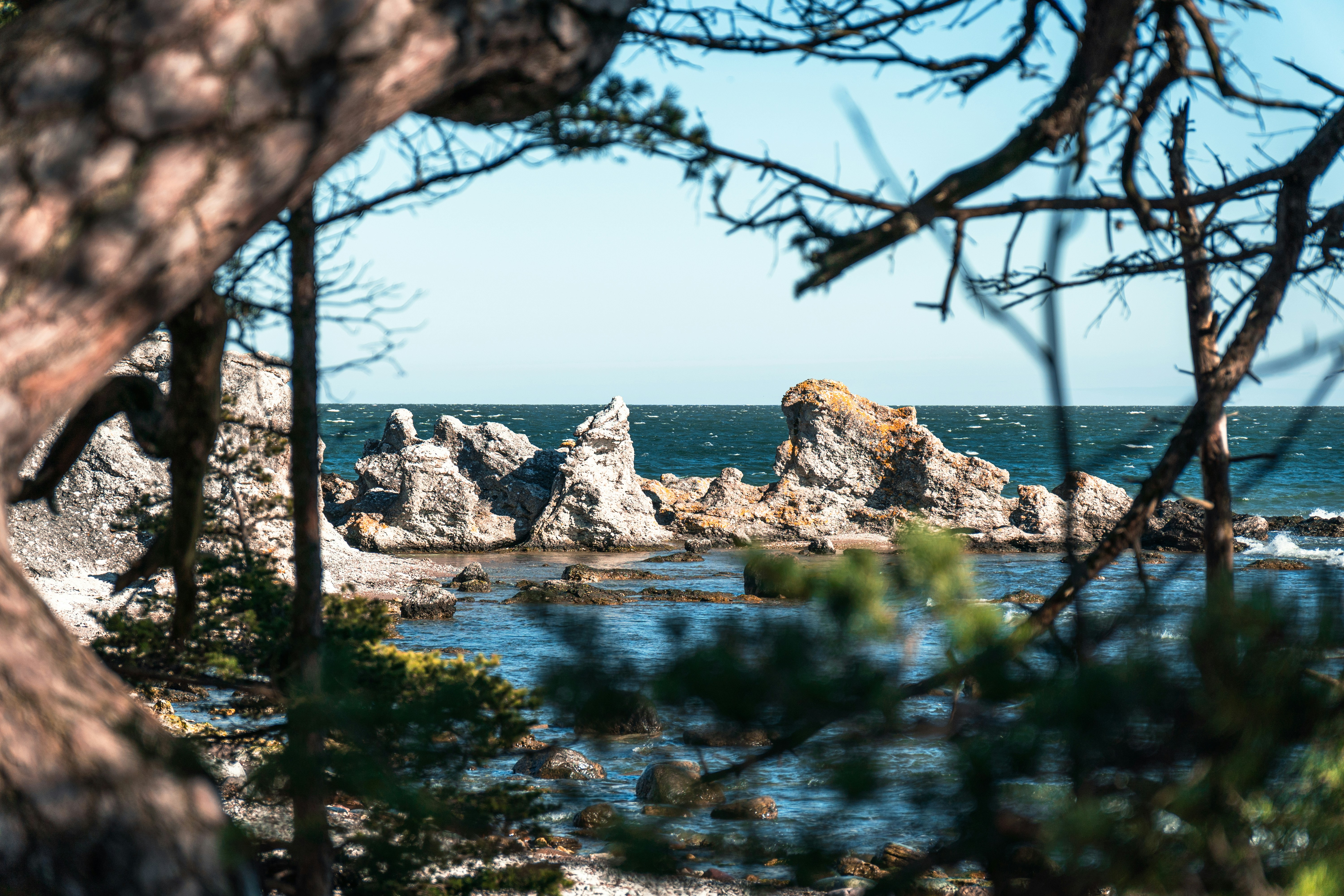 A rock outcropping in the middle of a body of water photo – Free ...