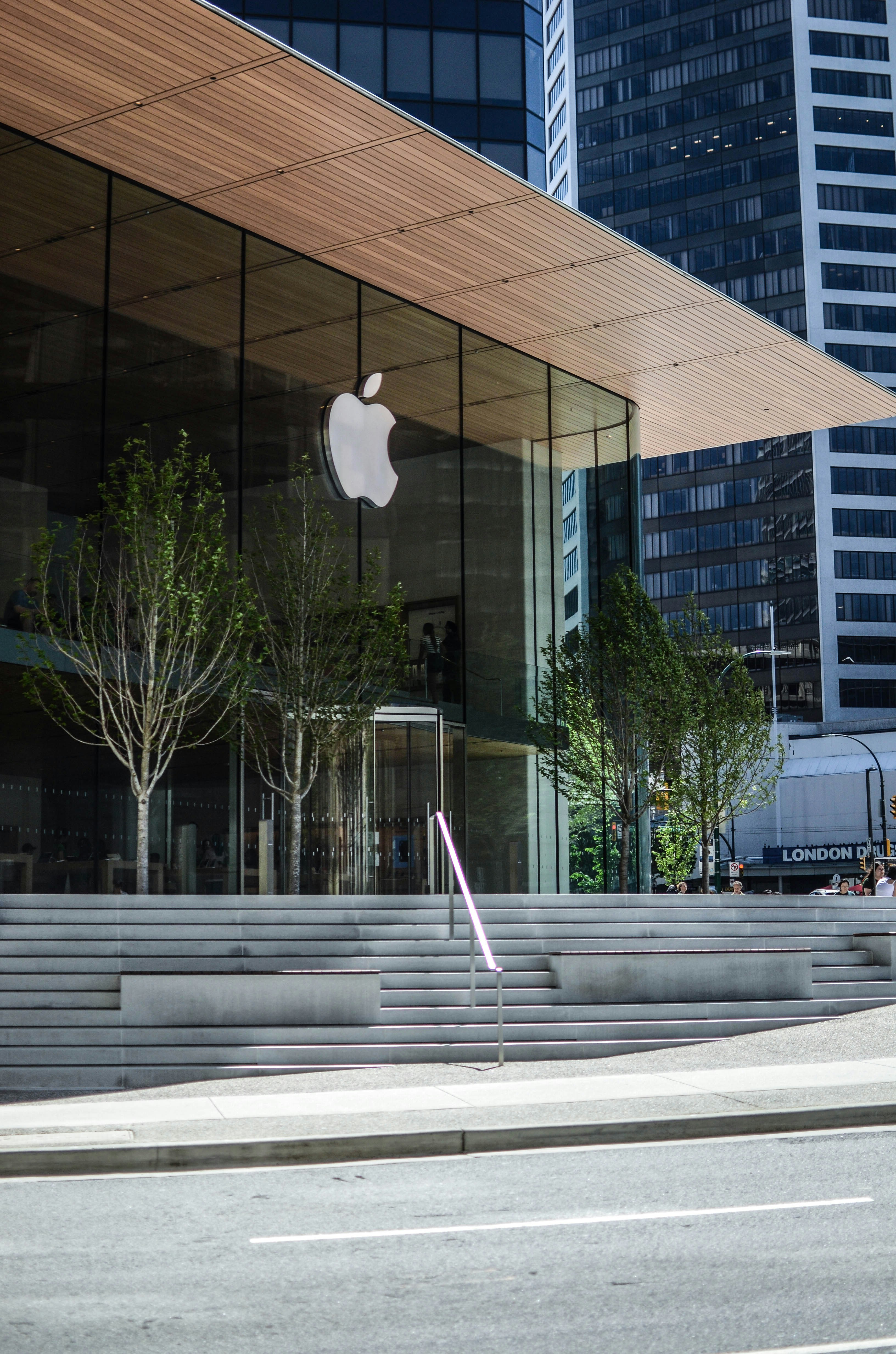 Apple Store facade showcasing sleek architecture with a prominent logo and landscaped surroundings.