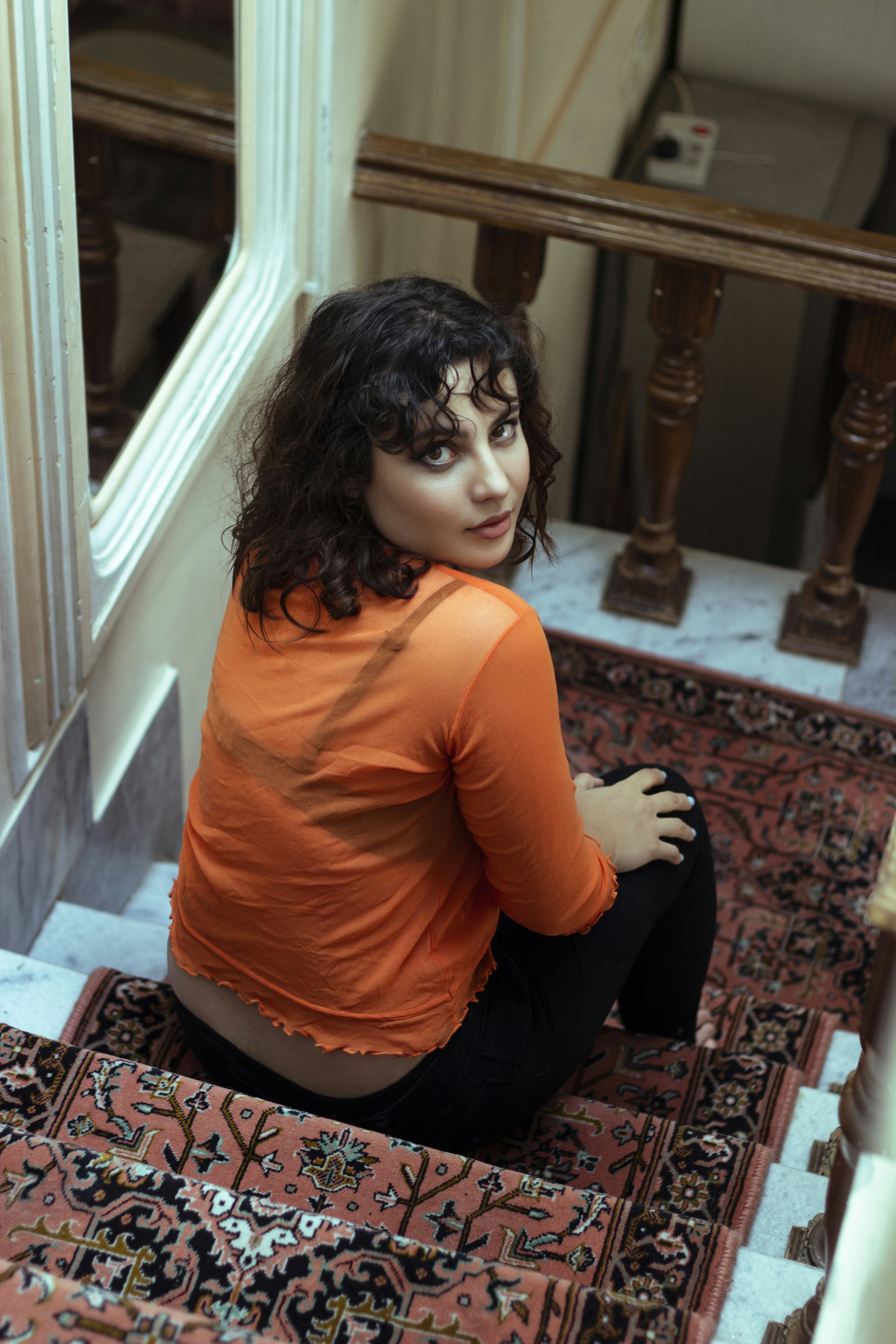 Amber Light on the Stairs: A Portrait Among Carved Railings