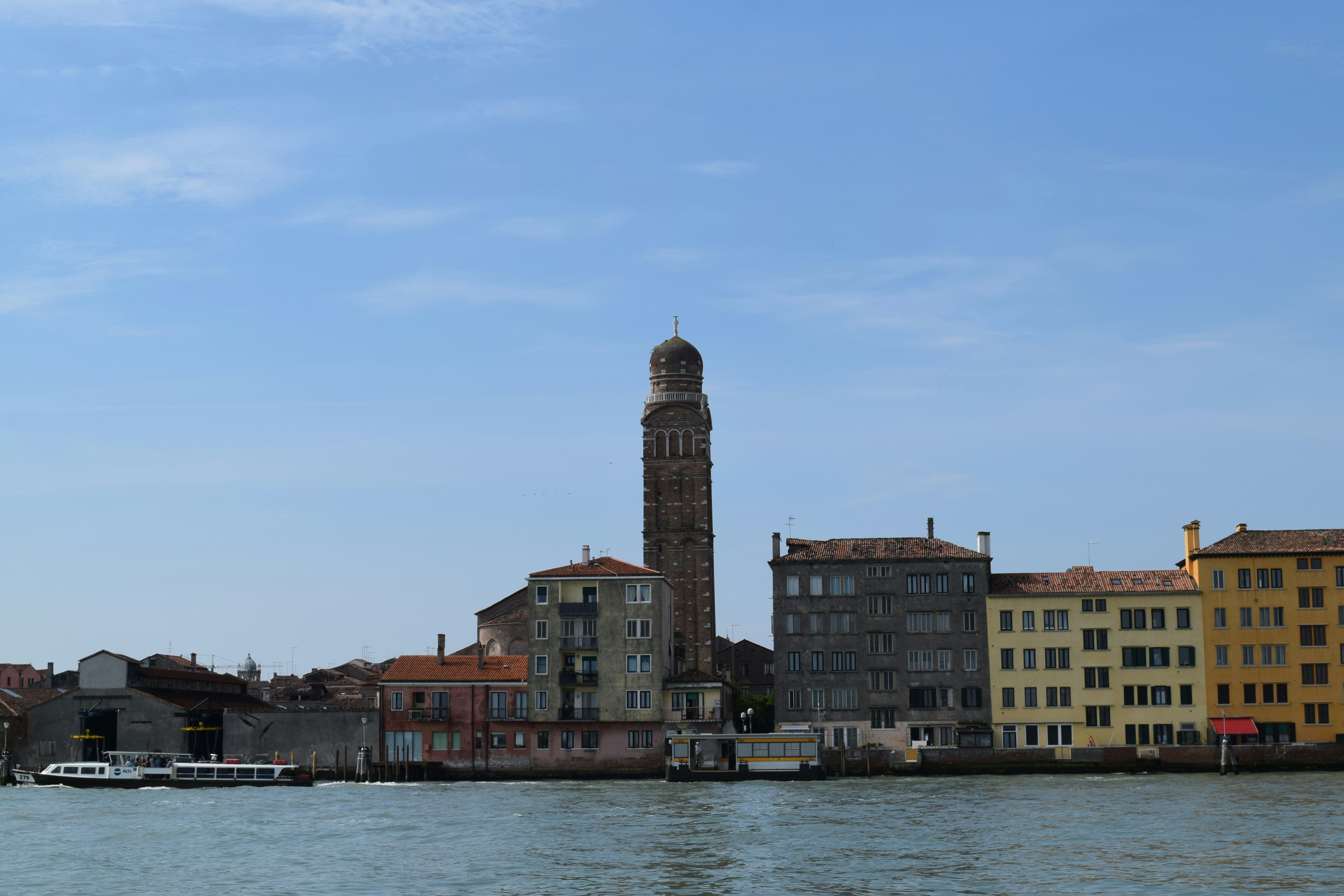 Cylindrical Bell Tower Rising Over a Colorful Waterfront