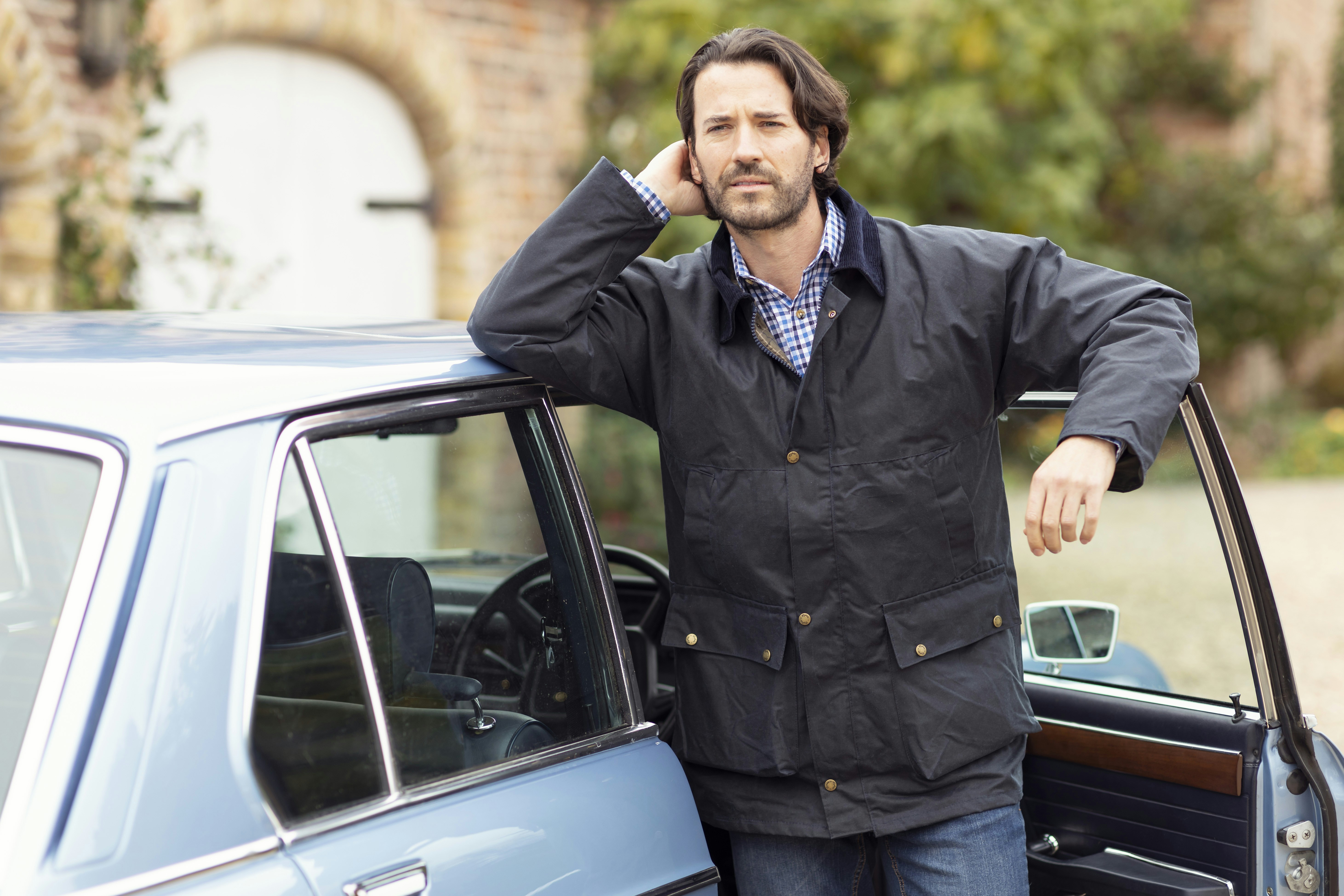 Relaxed Confidence: A Man Poses by a Classic Car