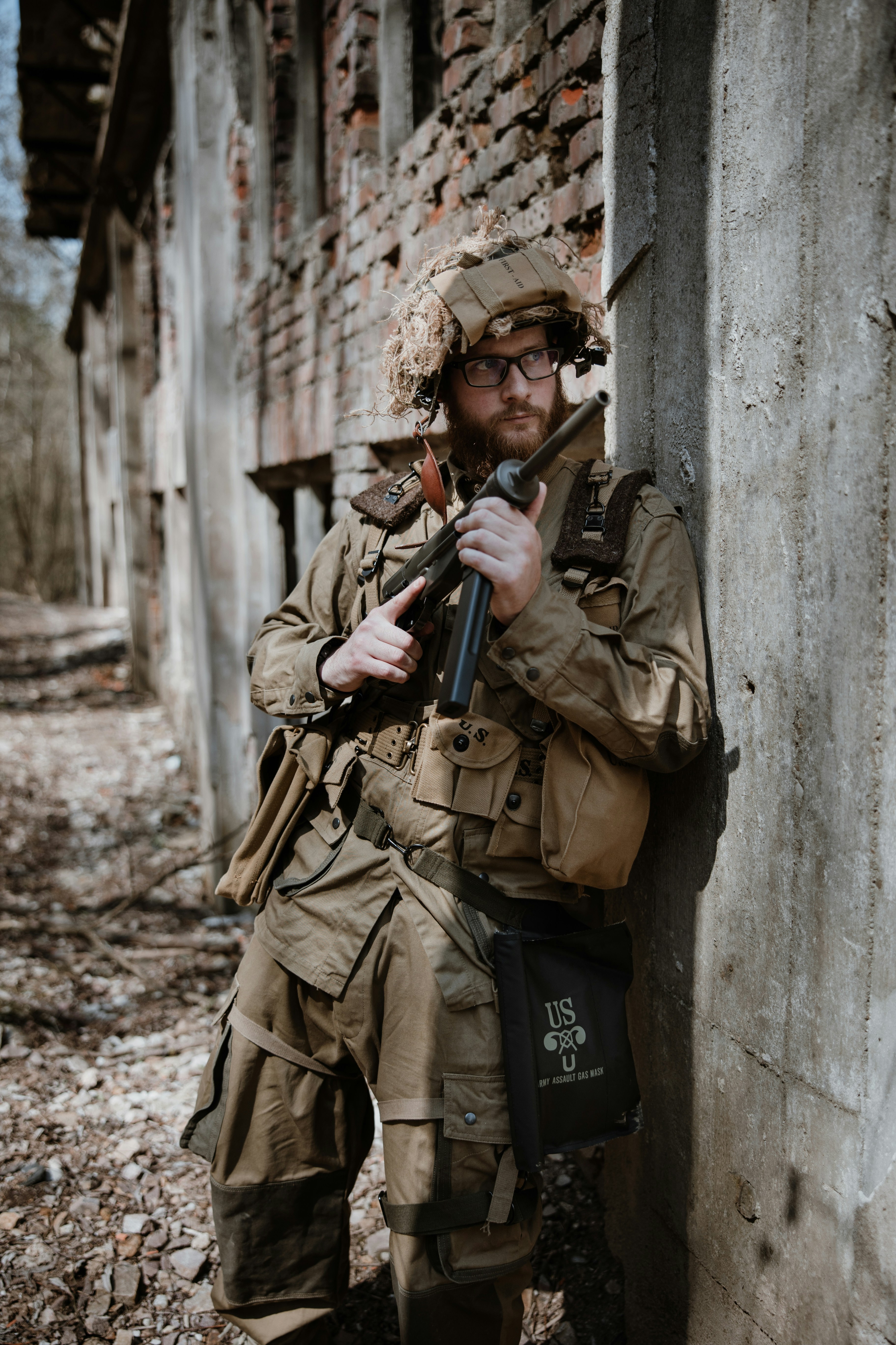 A man with a gun leaning against a wall photo – Free Airsoft outdoor ...