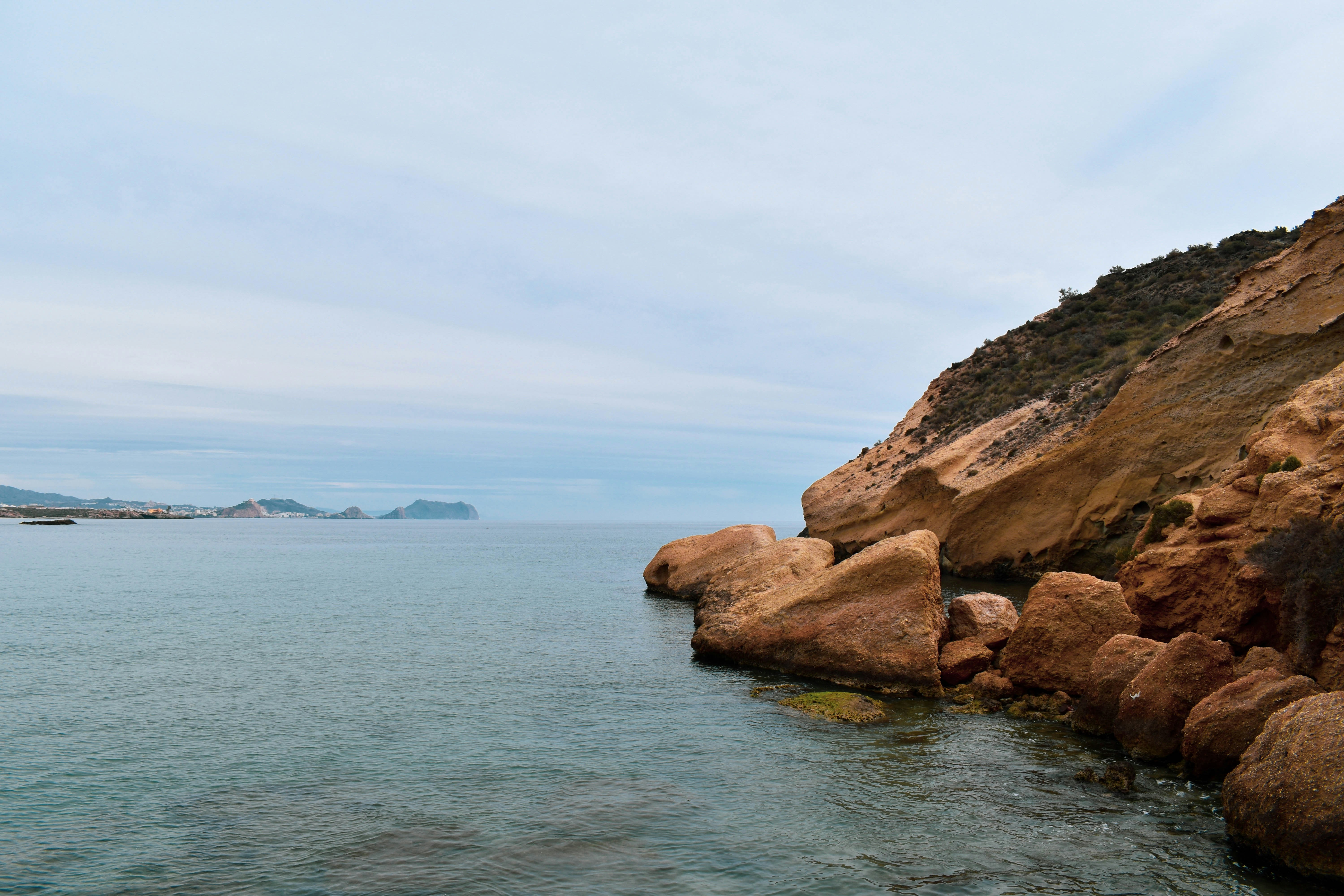 Un grand plan d’eau à côté d’une rive rocheuse photo – Photo Esthétique ...
