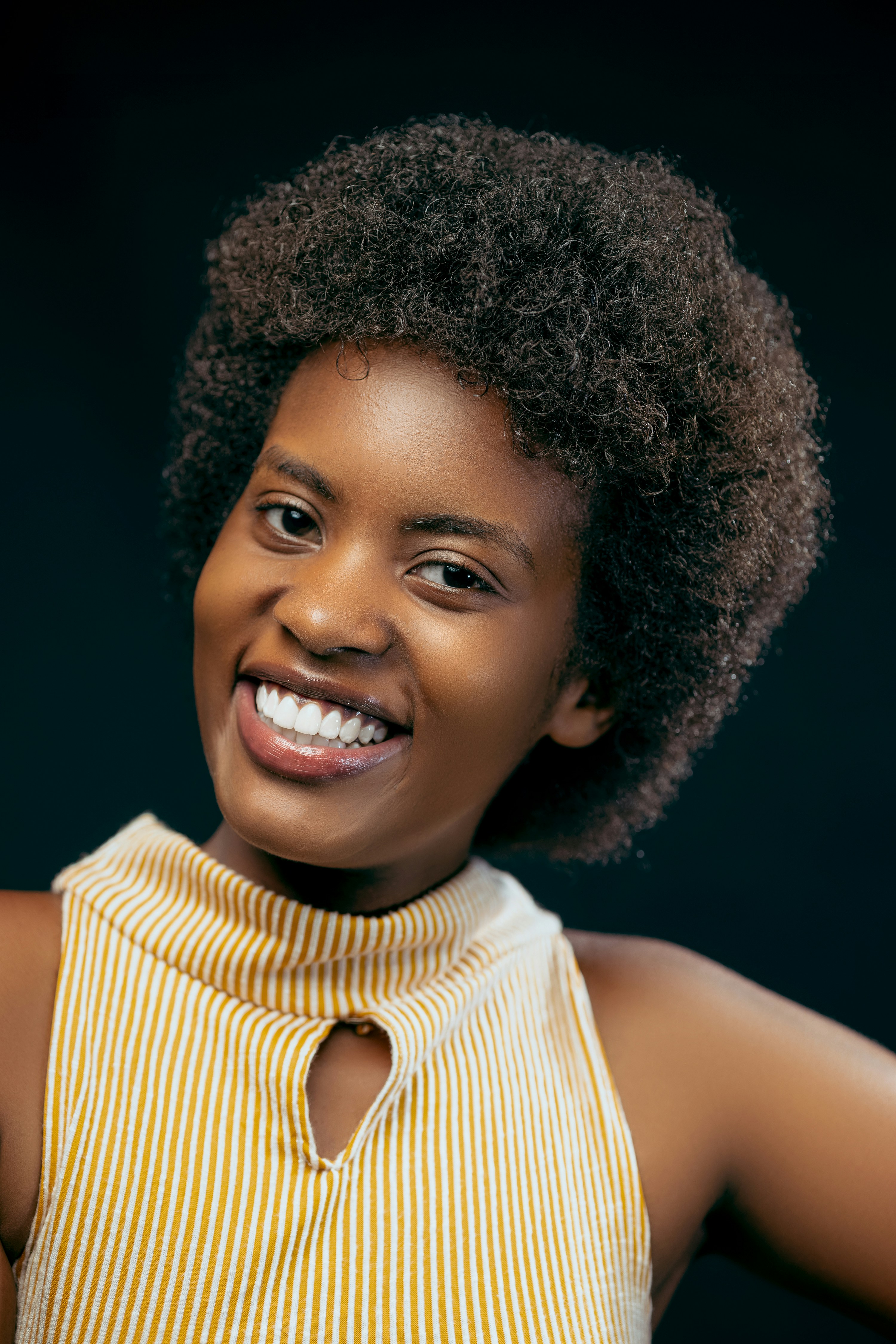 A woman with an afro is smiling at the camera photo – Free Portrait ...