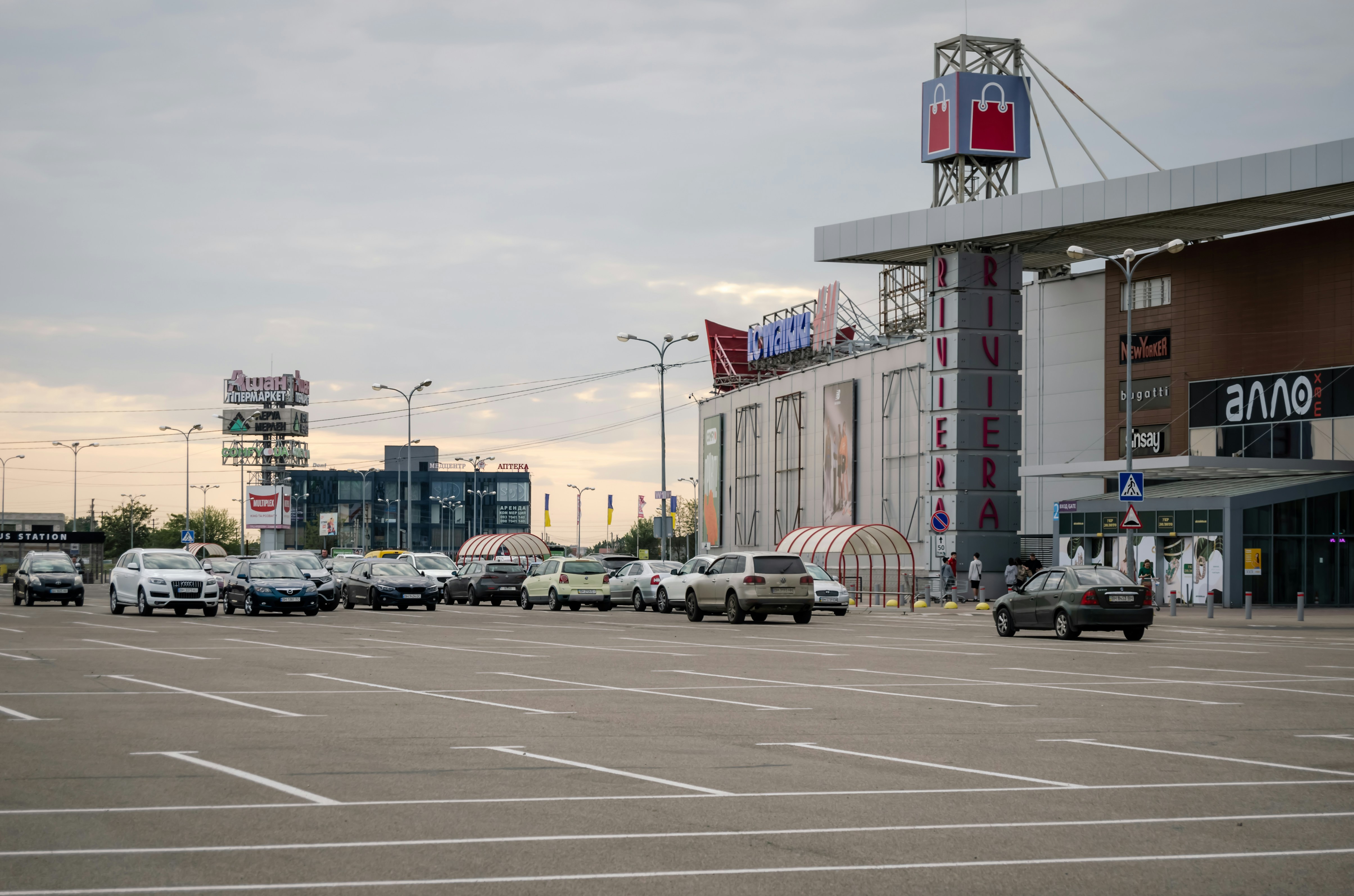 Evening Ledger: Rows of Cars Framing a Suburban Mall Facade
