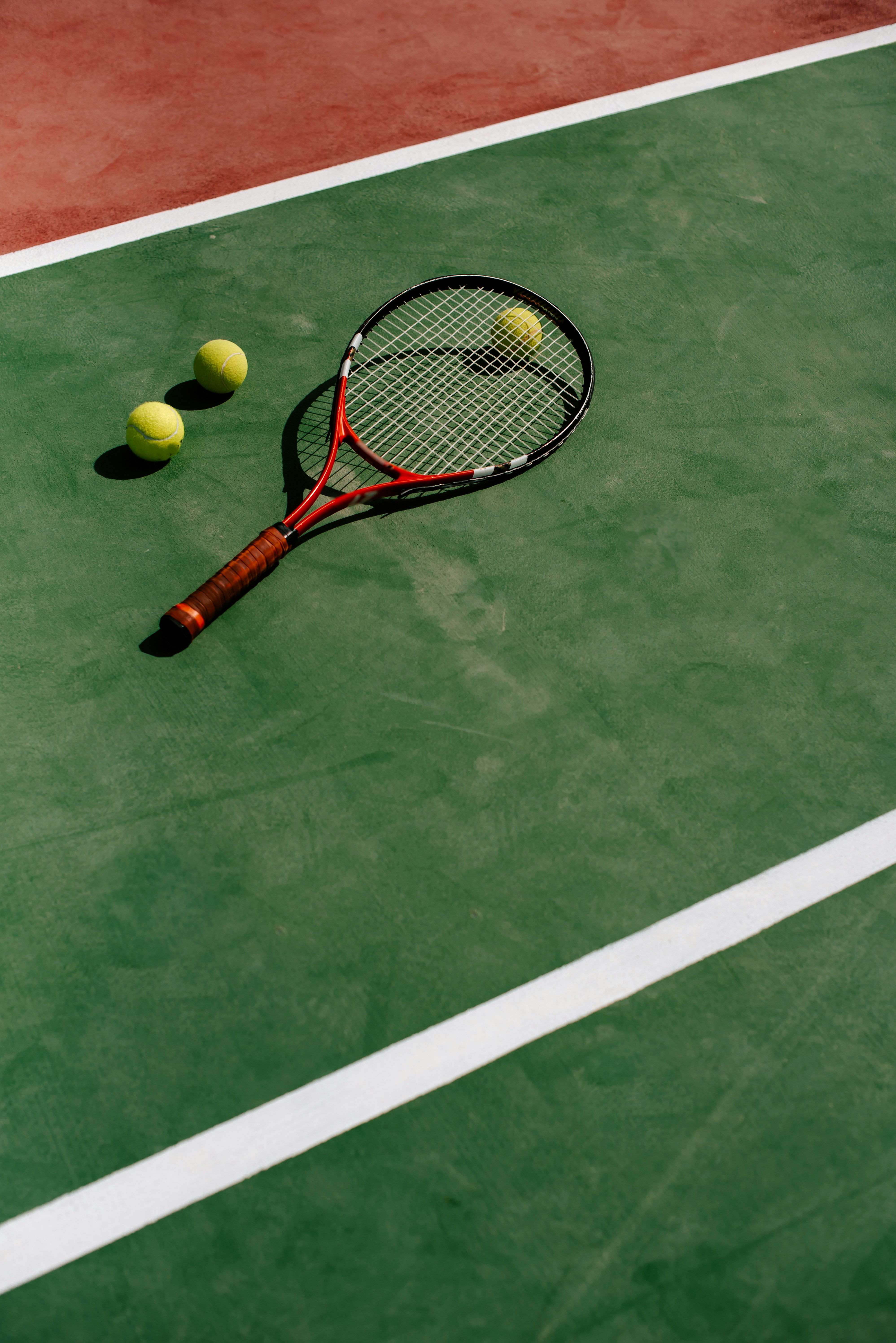 A tennis racket and three tennis balls on a court photo – Free Racket ...